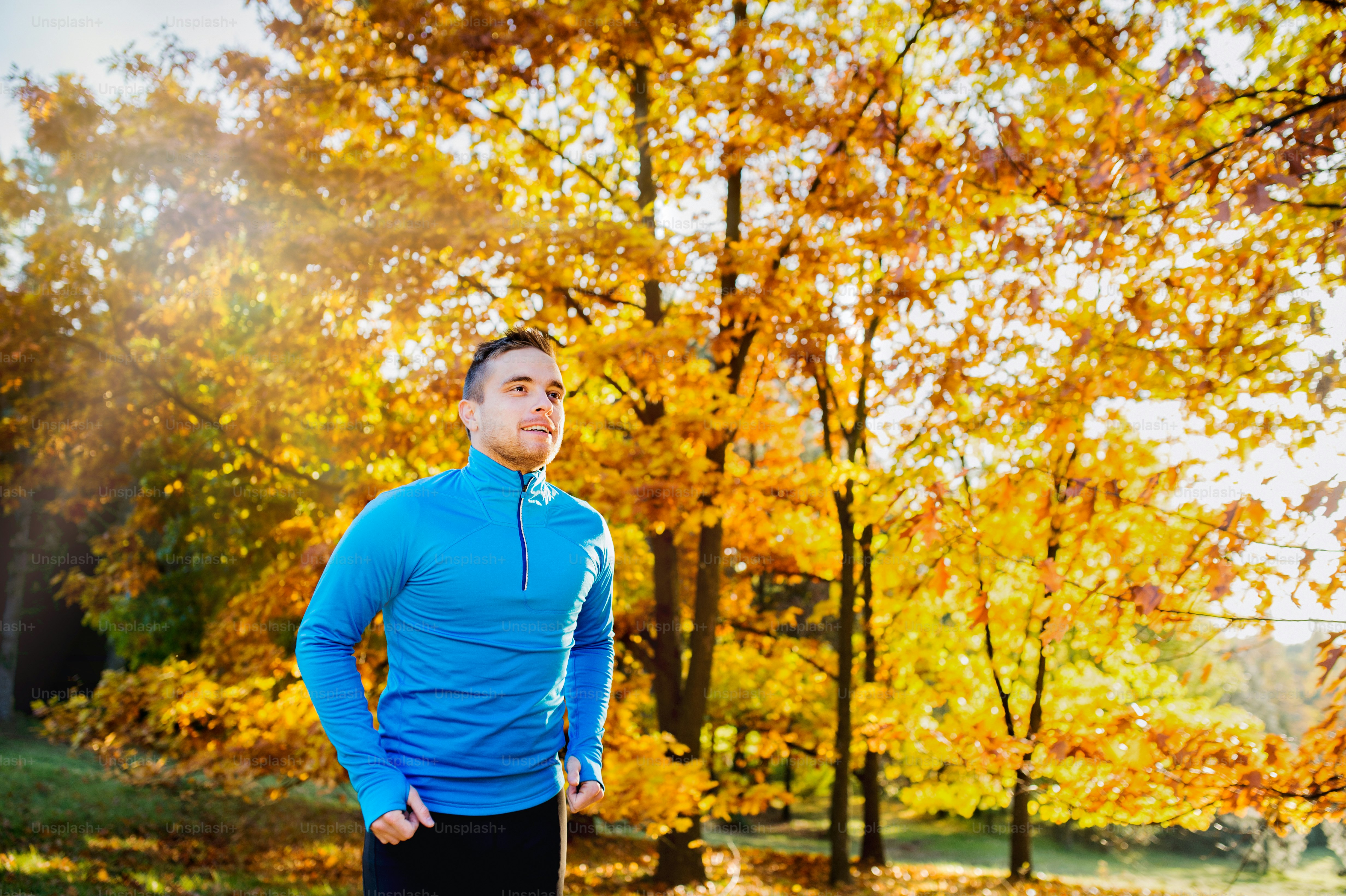 Young handsome hipster athlete in blue sweatshirt running outside in ...