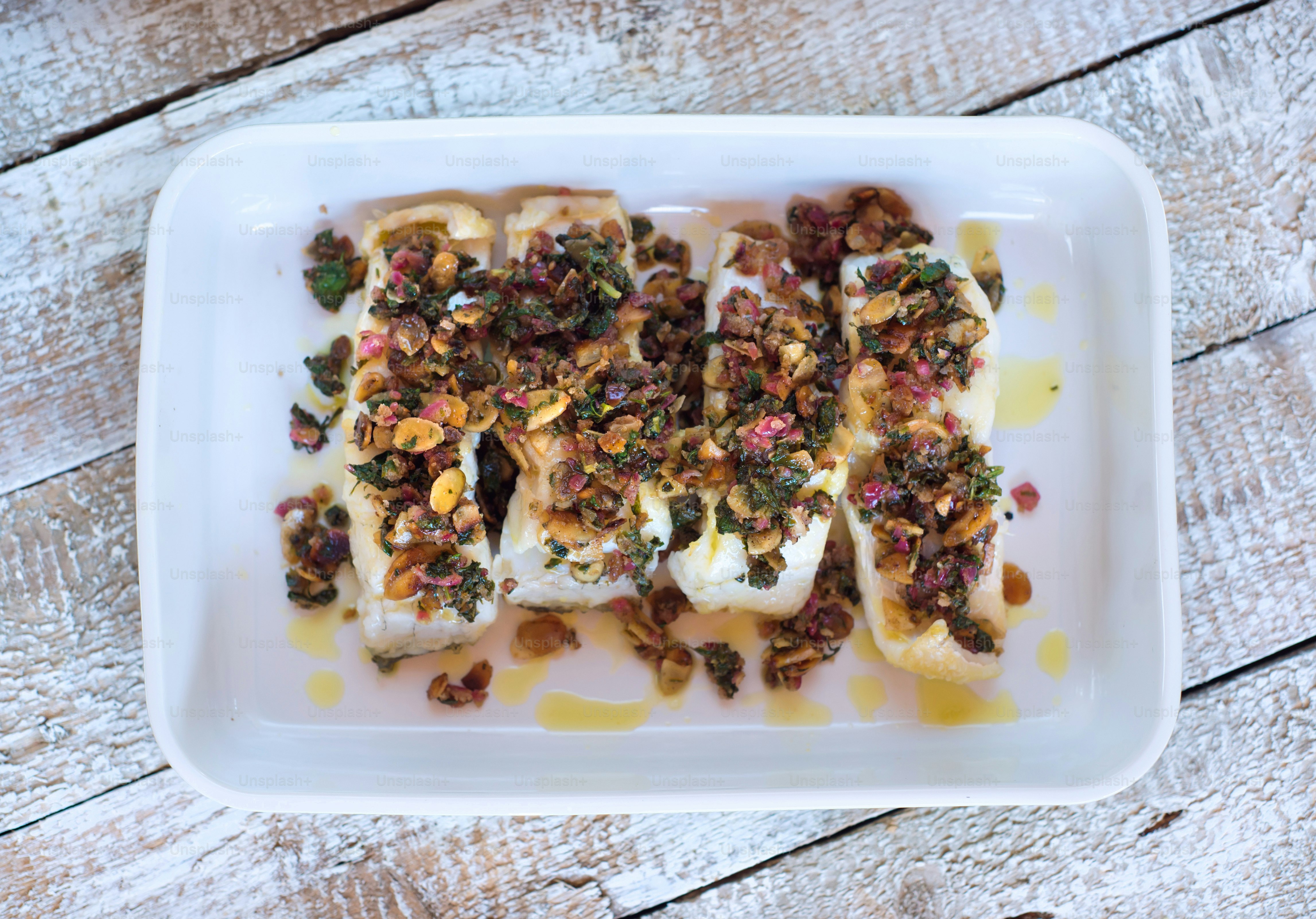 Zander fish fillets in ceramic dishware against white wooden table ...
