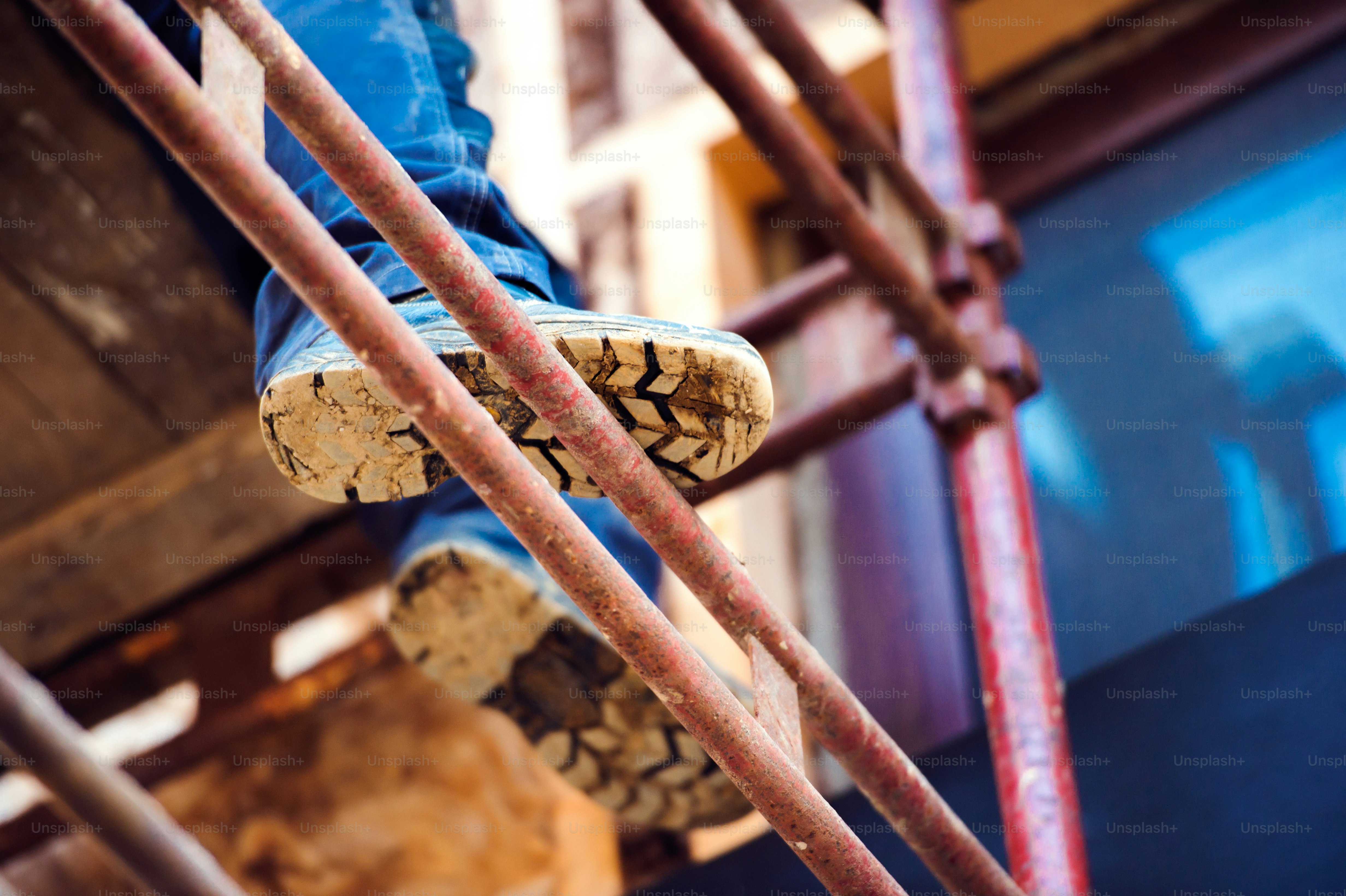 Close up of legs and soles of unrecognizable man standing on scaffold ...
