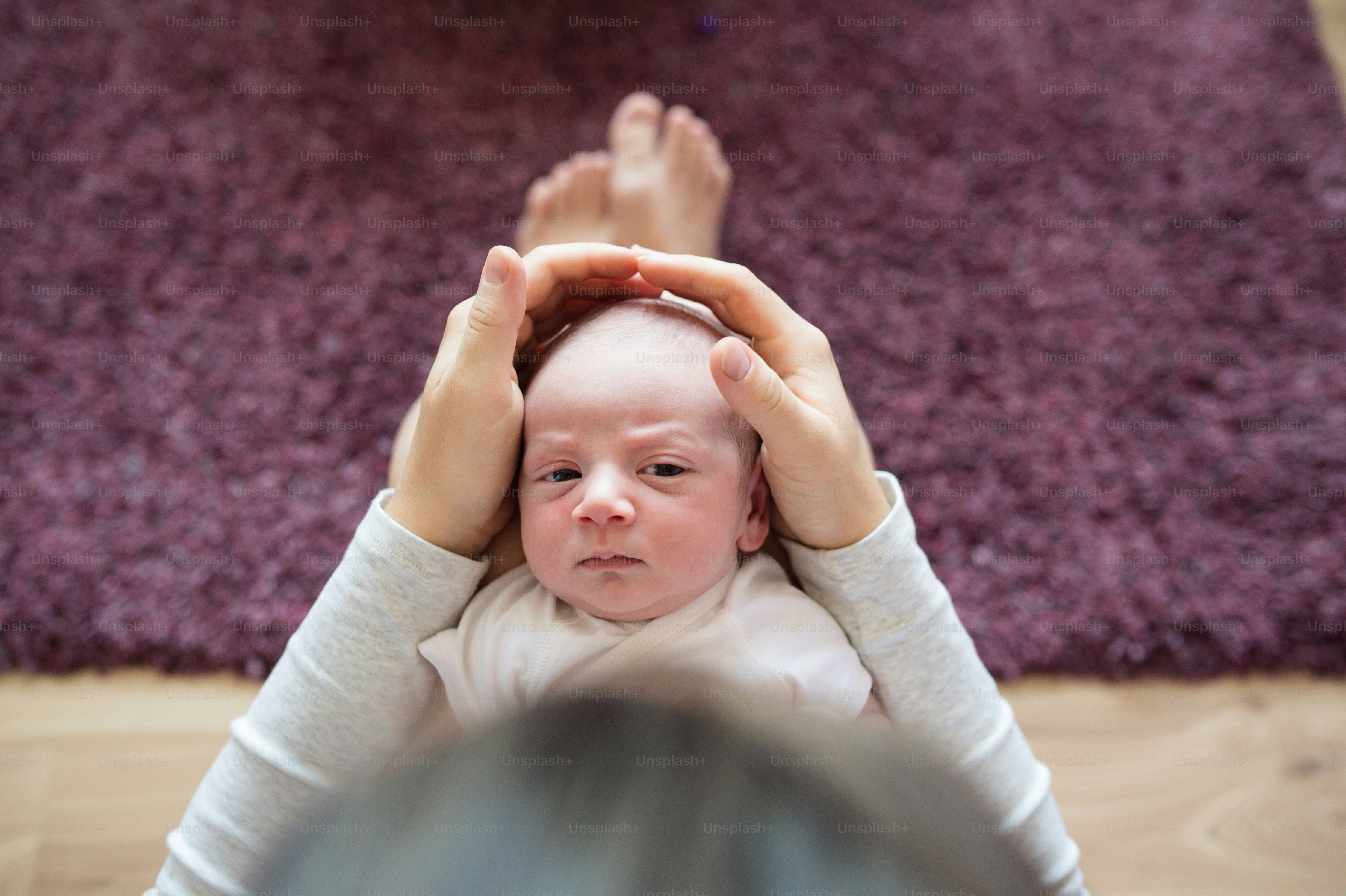 Unrecognizable young mother holding her newborn baby son. Close up ...