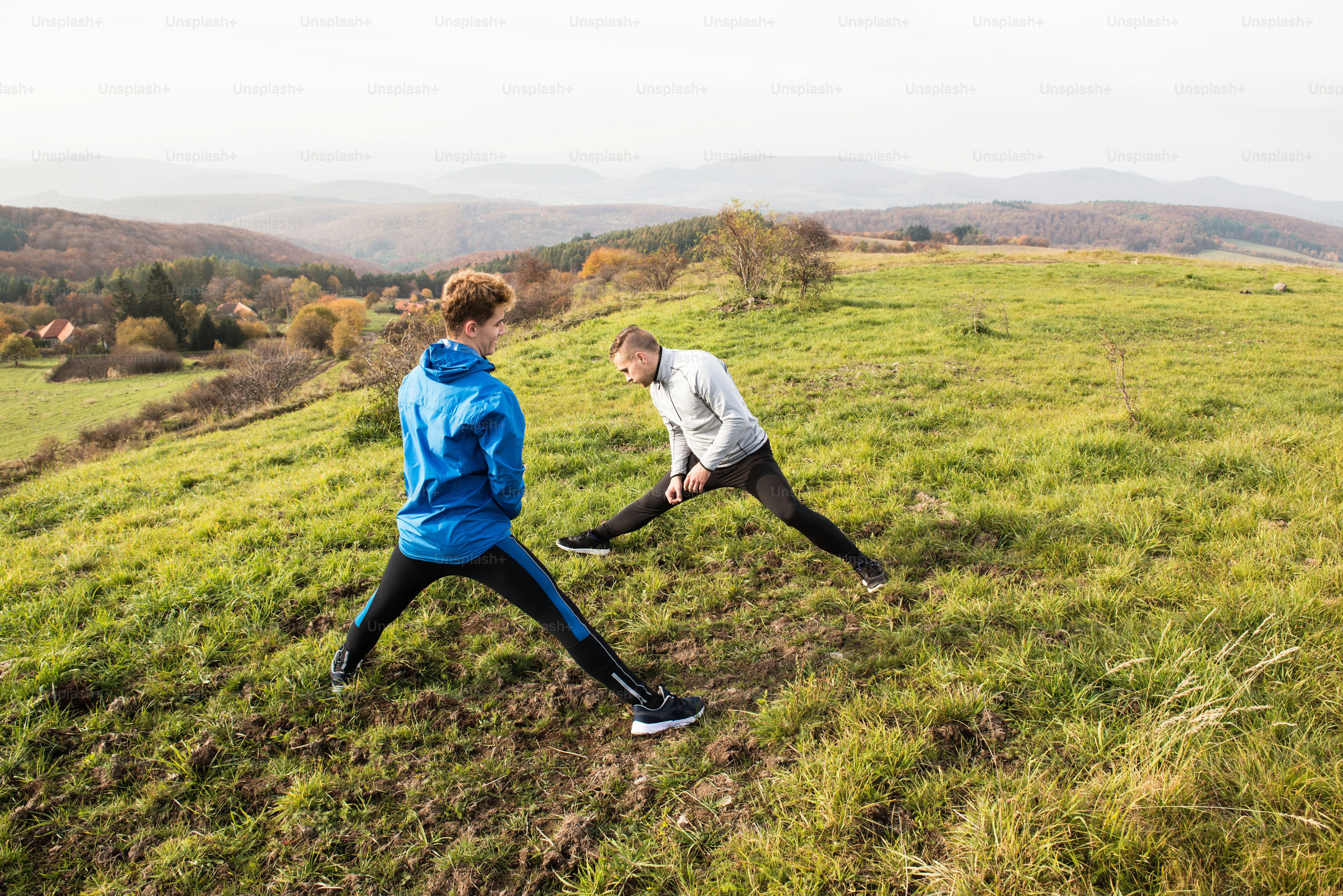 Two young handsome hipster runners in sports jackets in sunny autumn ...