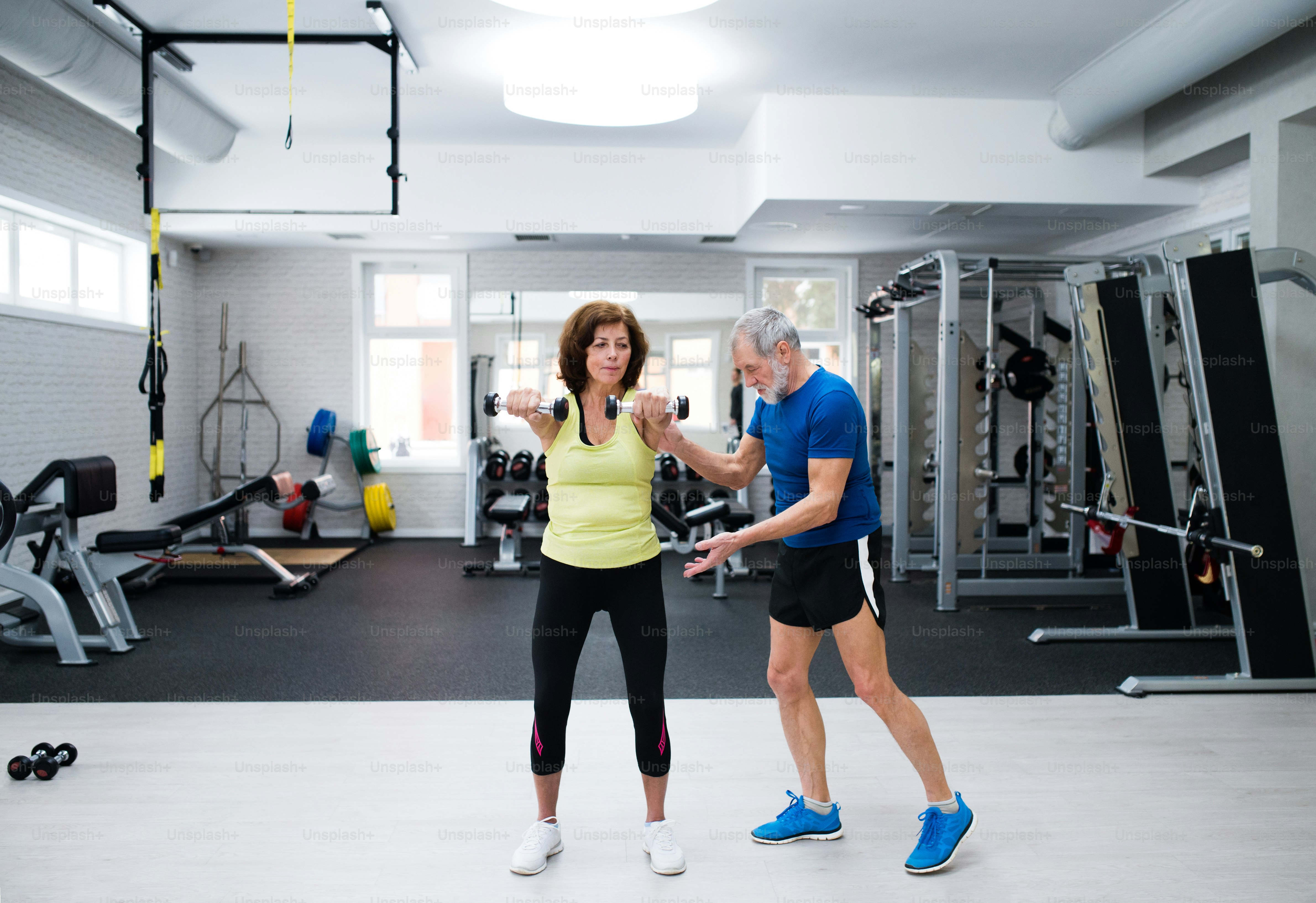 Hermosa pareja mayor en forma en ropa deportiva en gimnasio haciendo ...