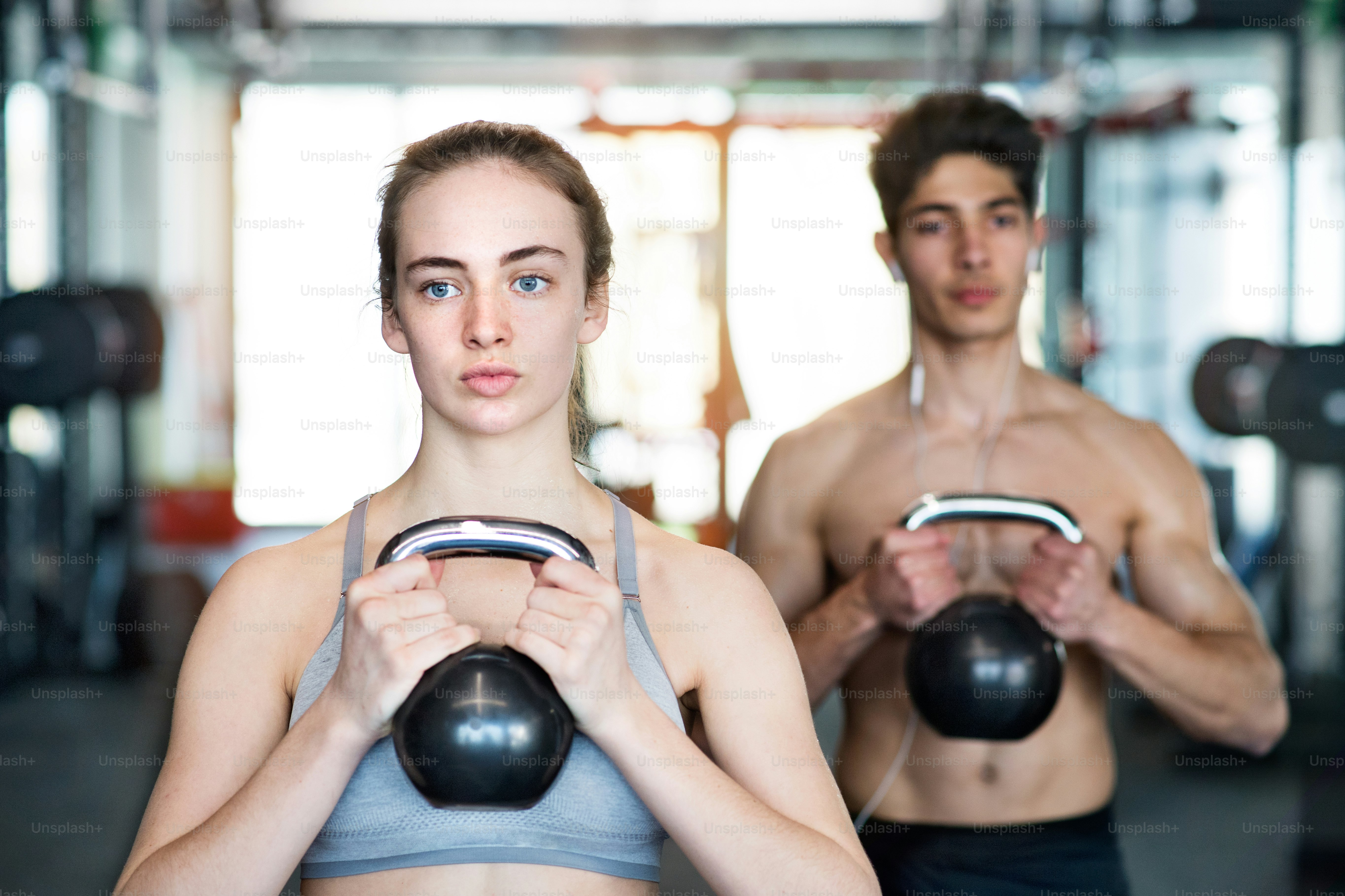 Beautiful young fit couple doing strength training, exercising with ...