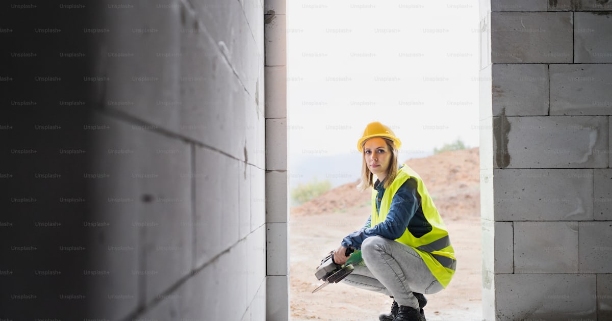建設現場の女性作業員。電動工具で作業する美しい若い女性。の写真 Unsplashのスロバキアの画像