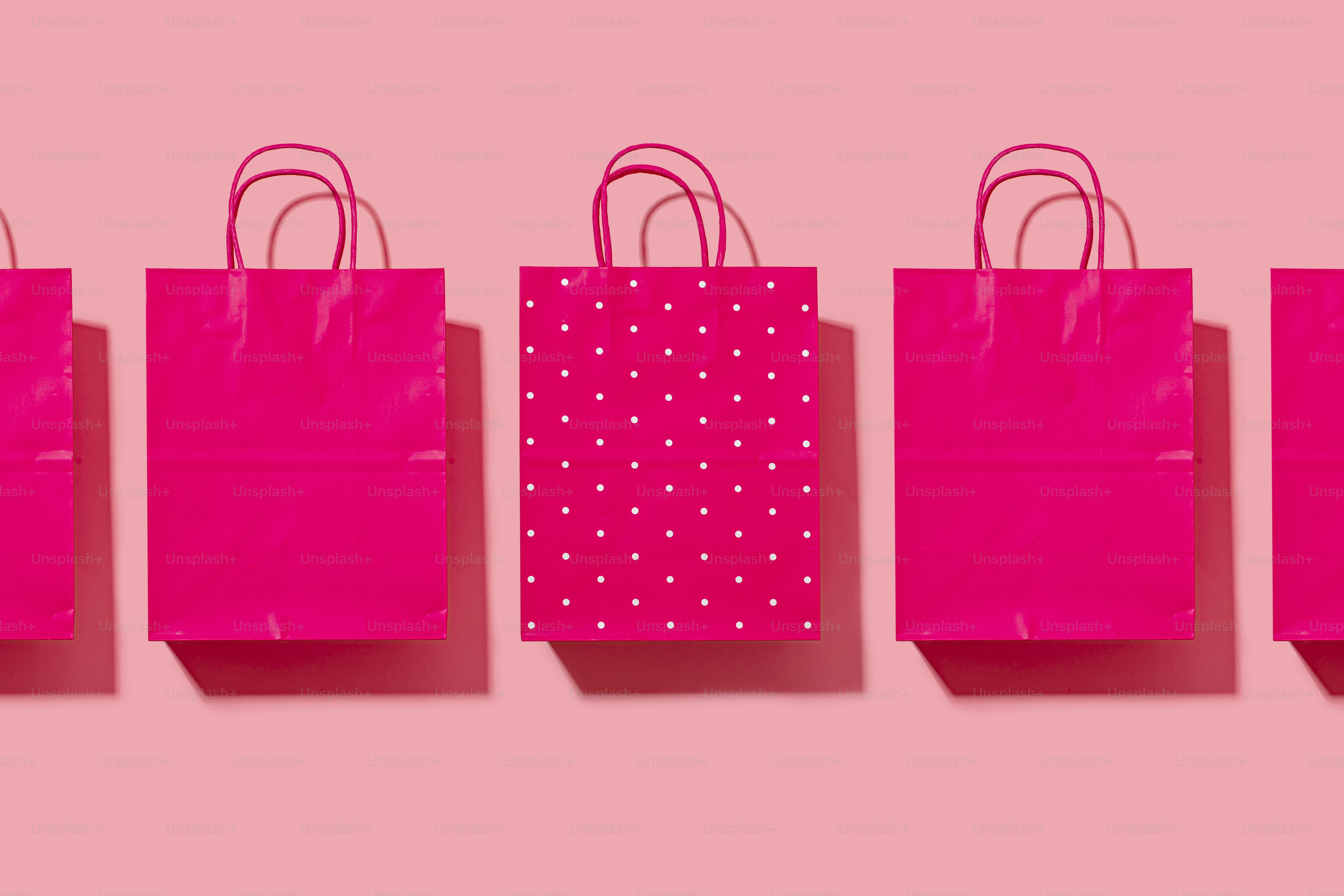 A row of pink shopping bags on a pink background photo – Bag Image on ...