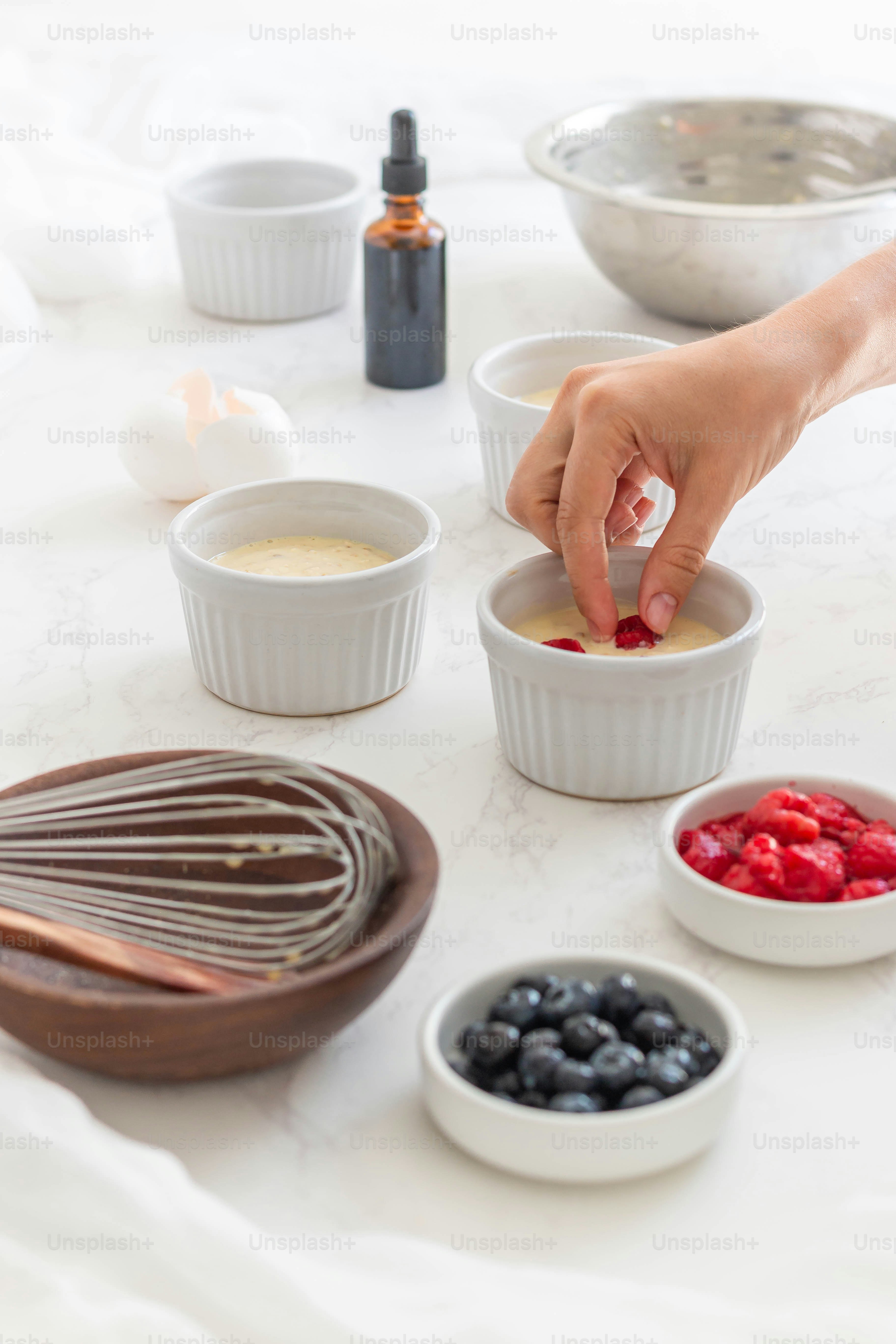 A person mixing ingredients in bowls on a table photo – Food Image on ...