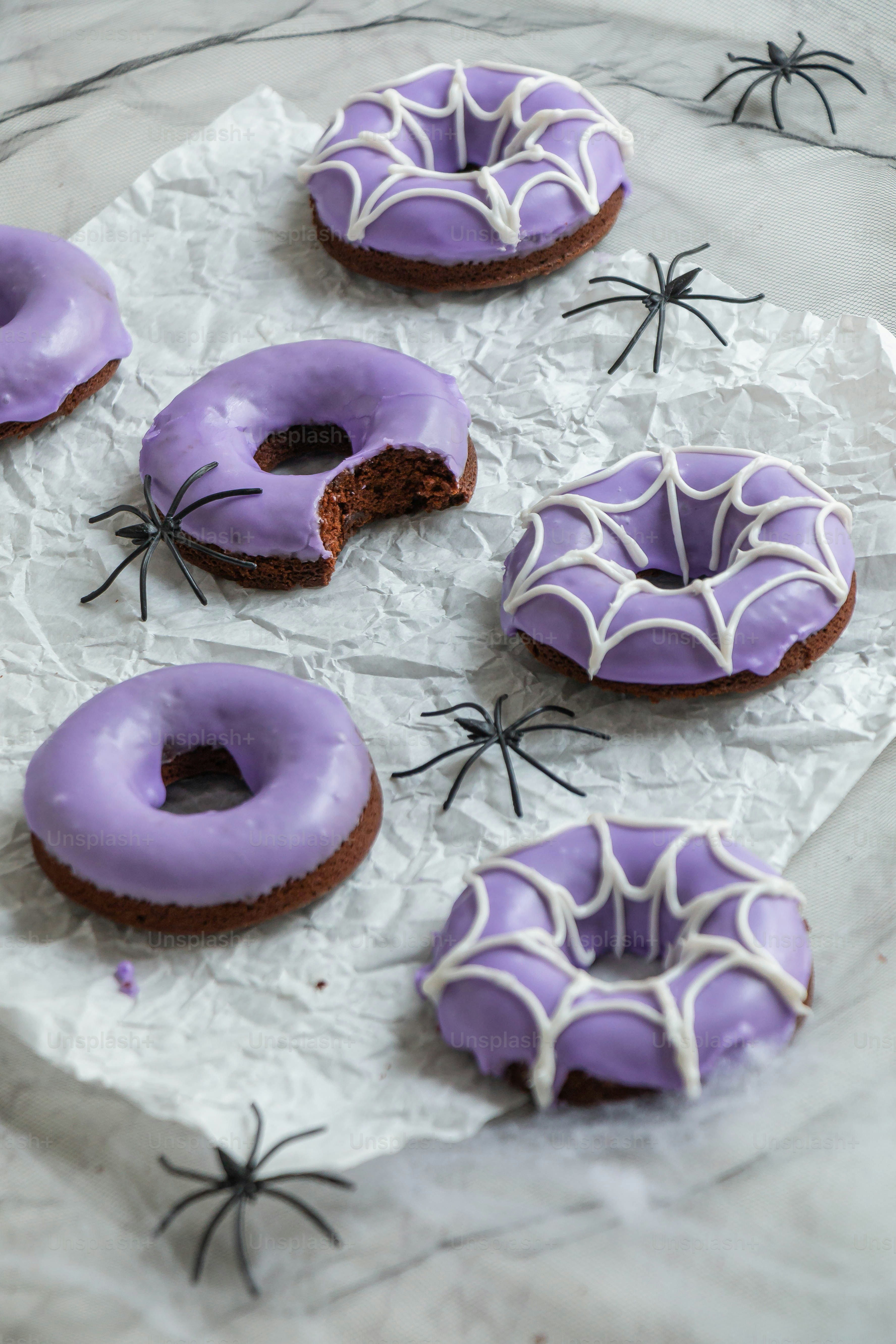 Donas esmeriladas moradas con chispas blancas en un plato foto – Imagen ...