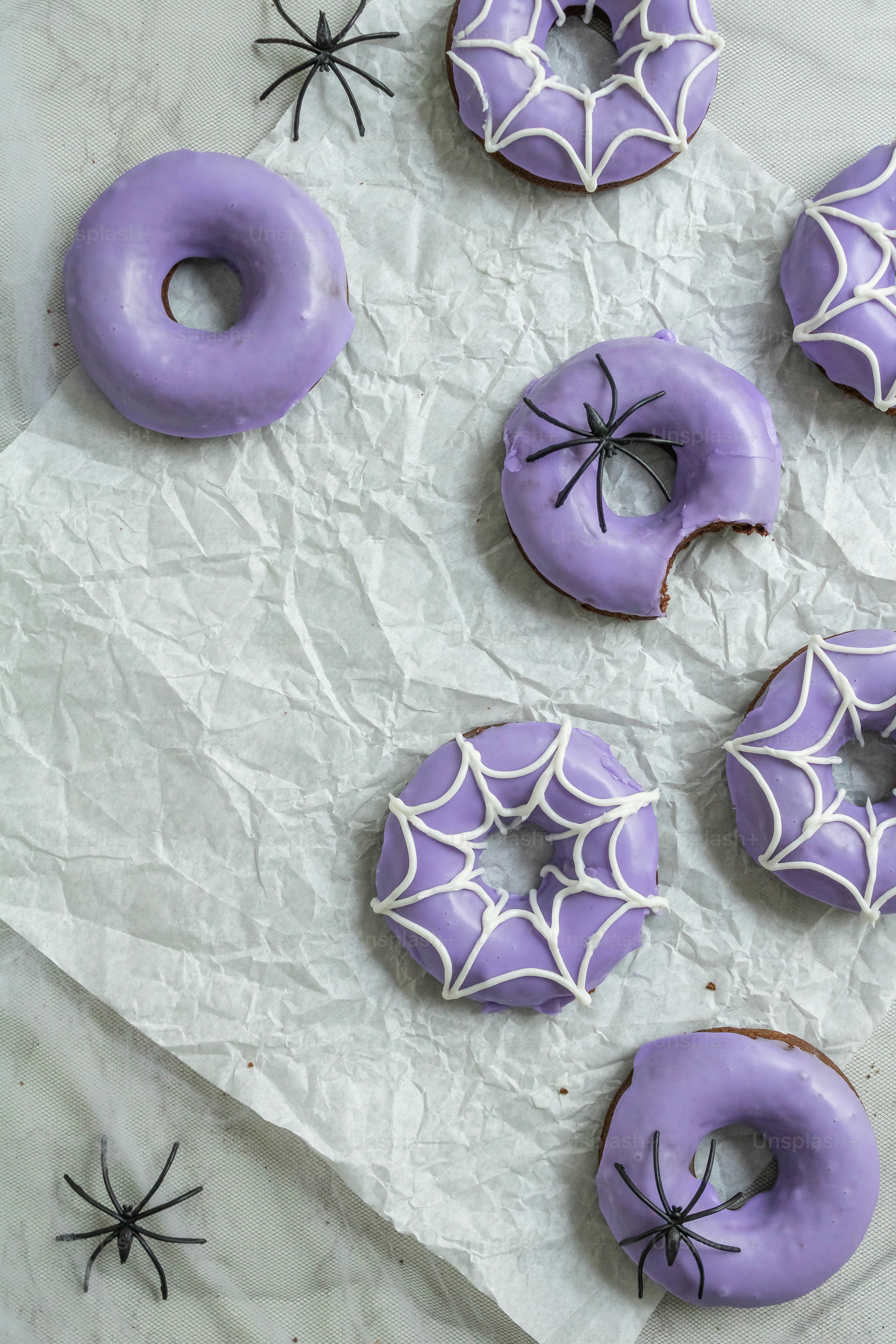 Una mesa cubierta con donas moradas cubiertas de glaseado foto – Imagen ...