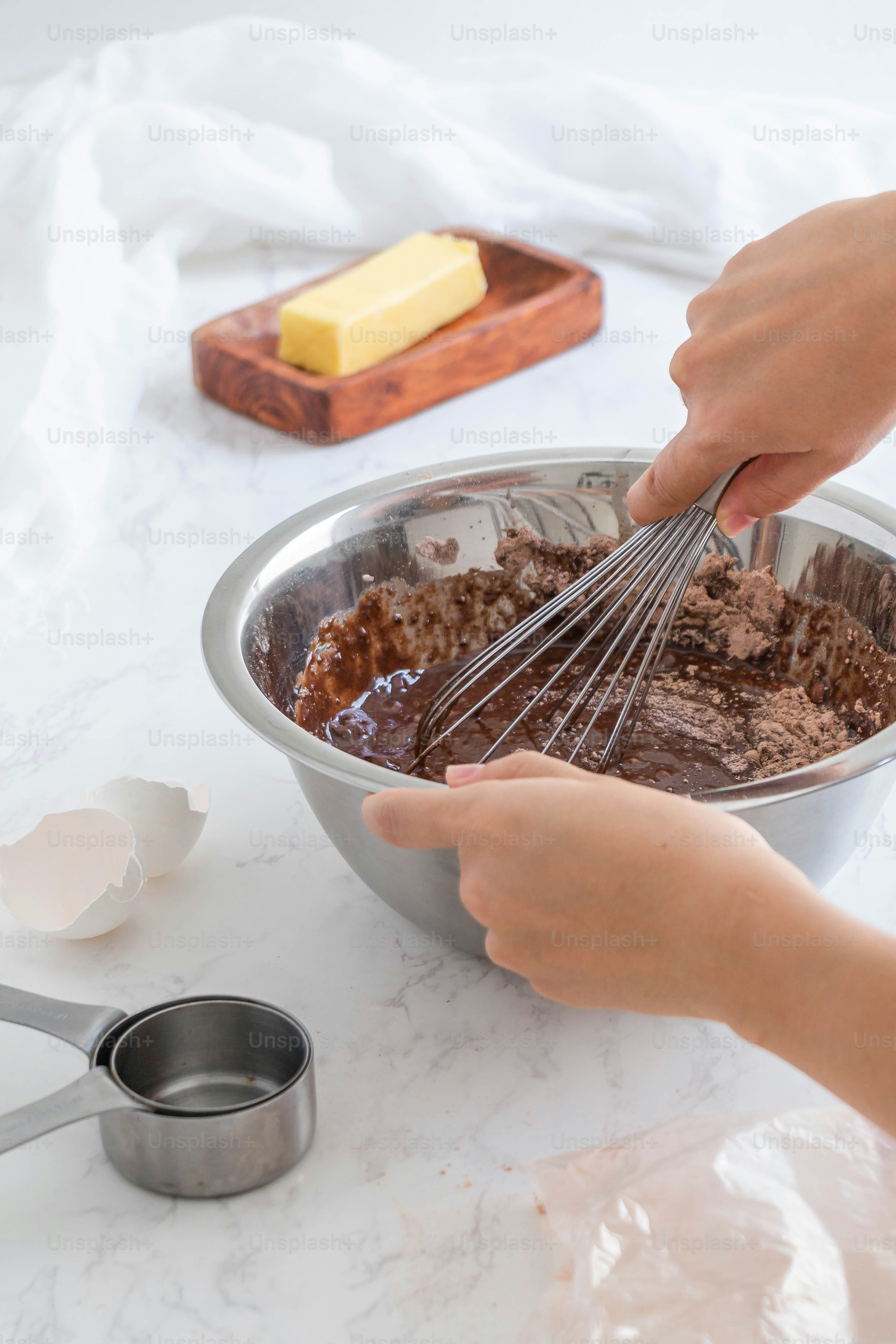Foto Una persona batiendo chocolate en un tazón – Hacer pastel Imagen ...
