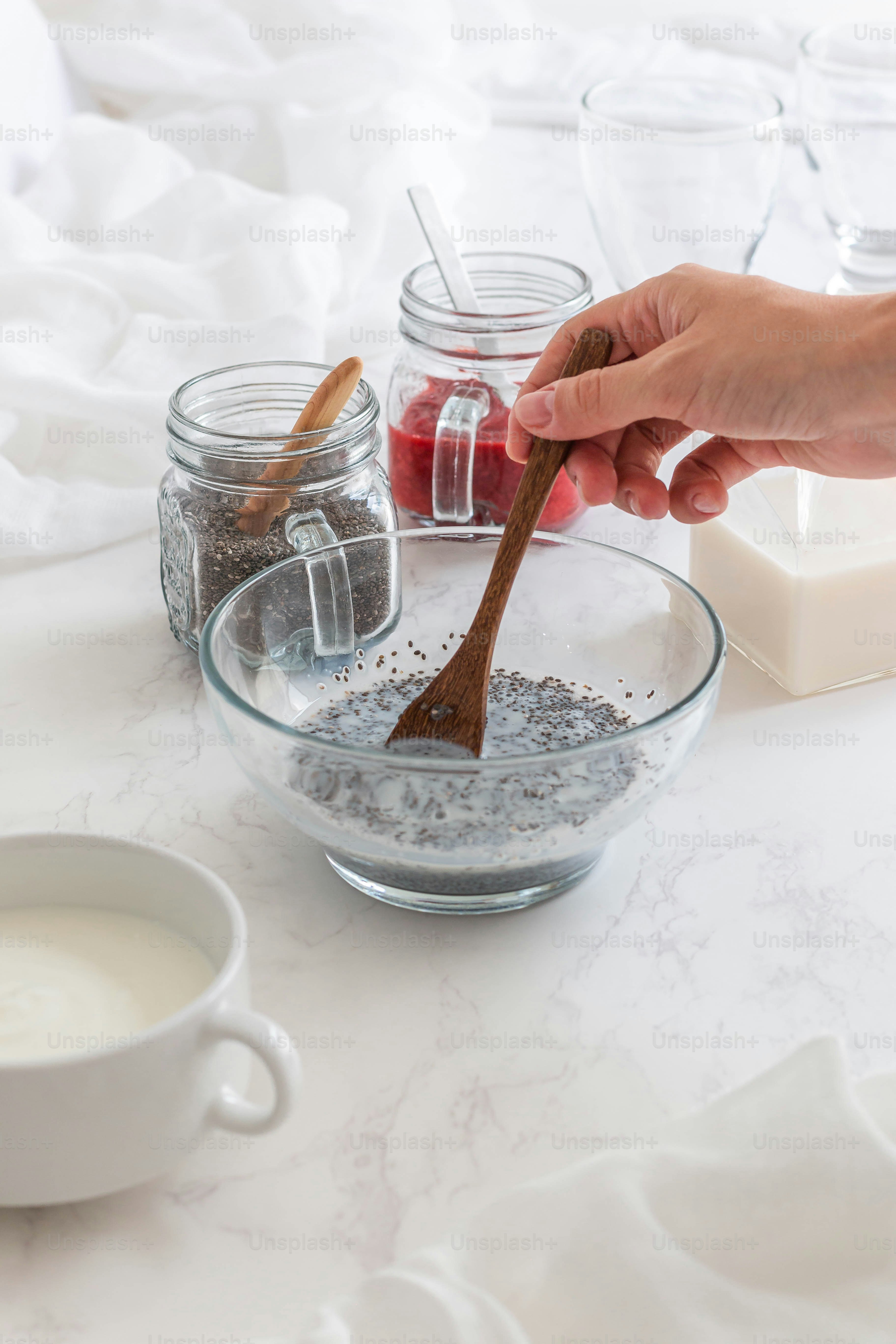 A person spooning something into a bowl of food photo – Chia pudding ...