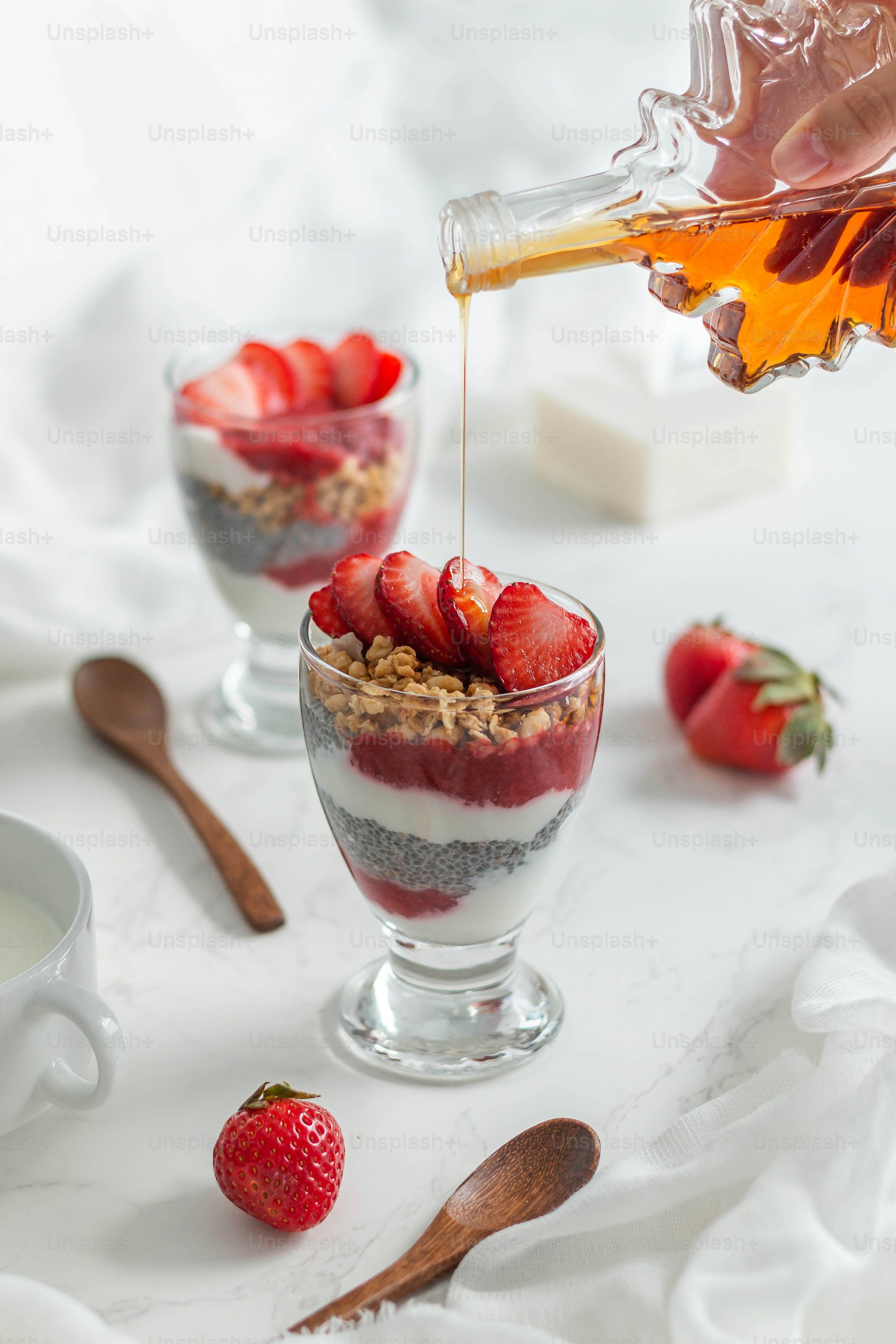 A person pouring syrup into a bowl of food photo – Maple syrup Image on ...