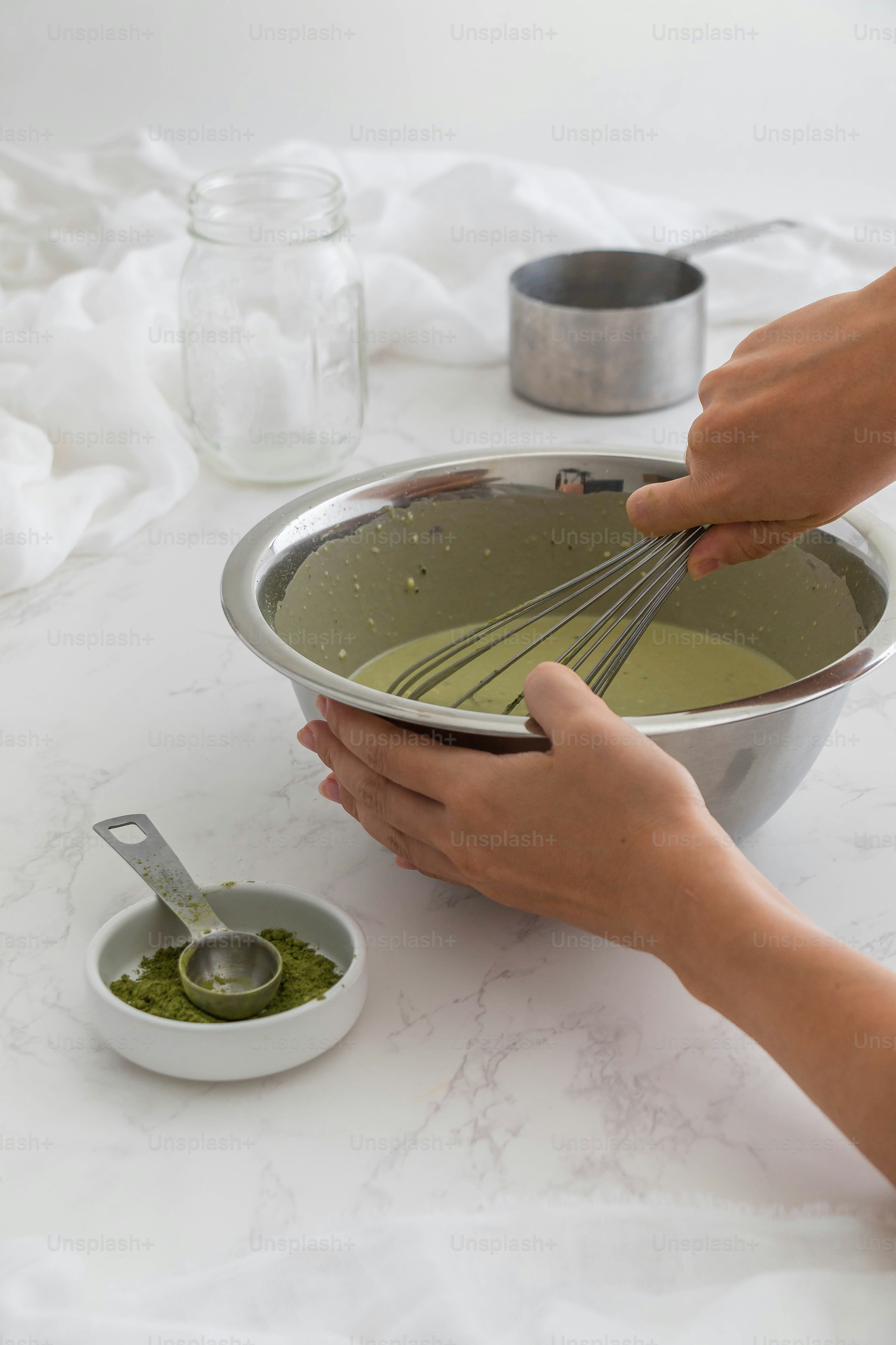 A person mixing something in a bowl with a whisk photo – Making ...