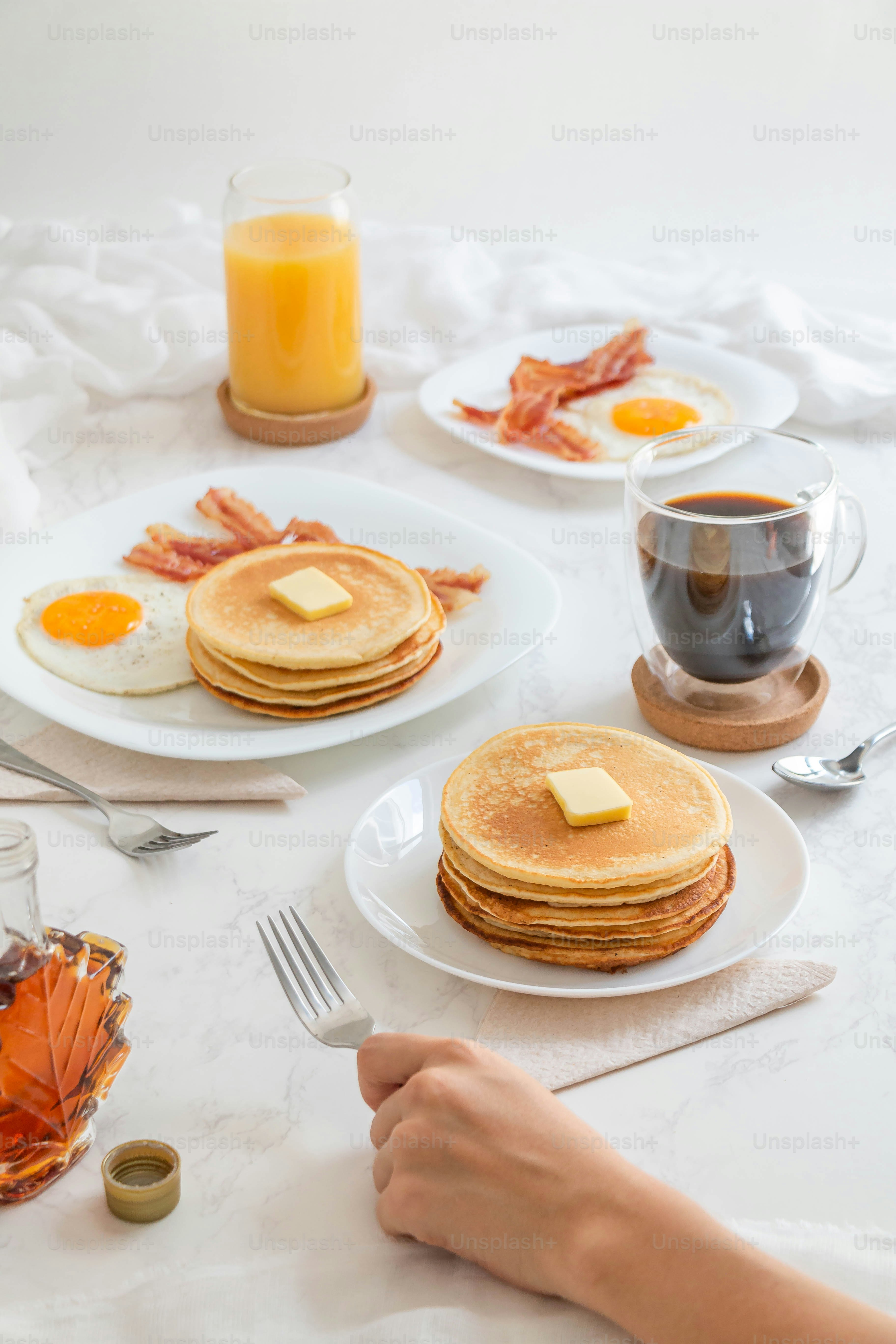 A table topped with pancakes and bacon next to a cup of coffee photo ...