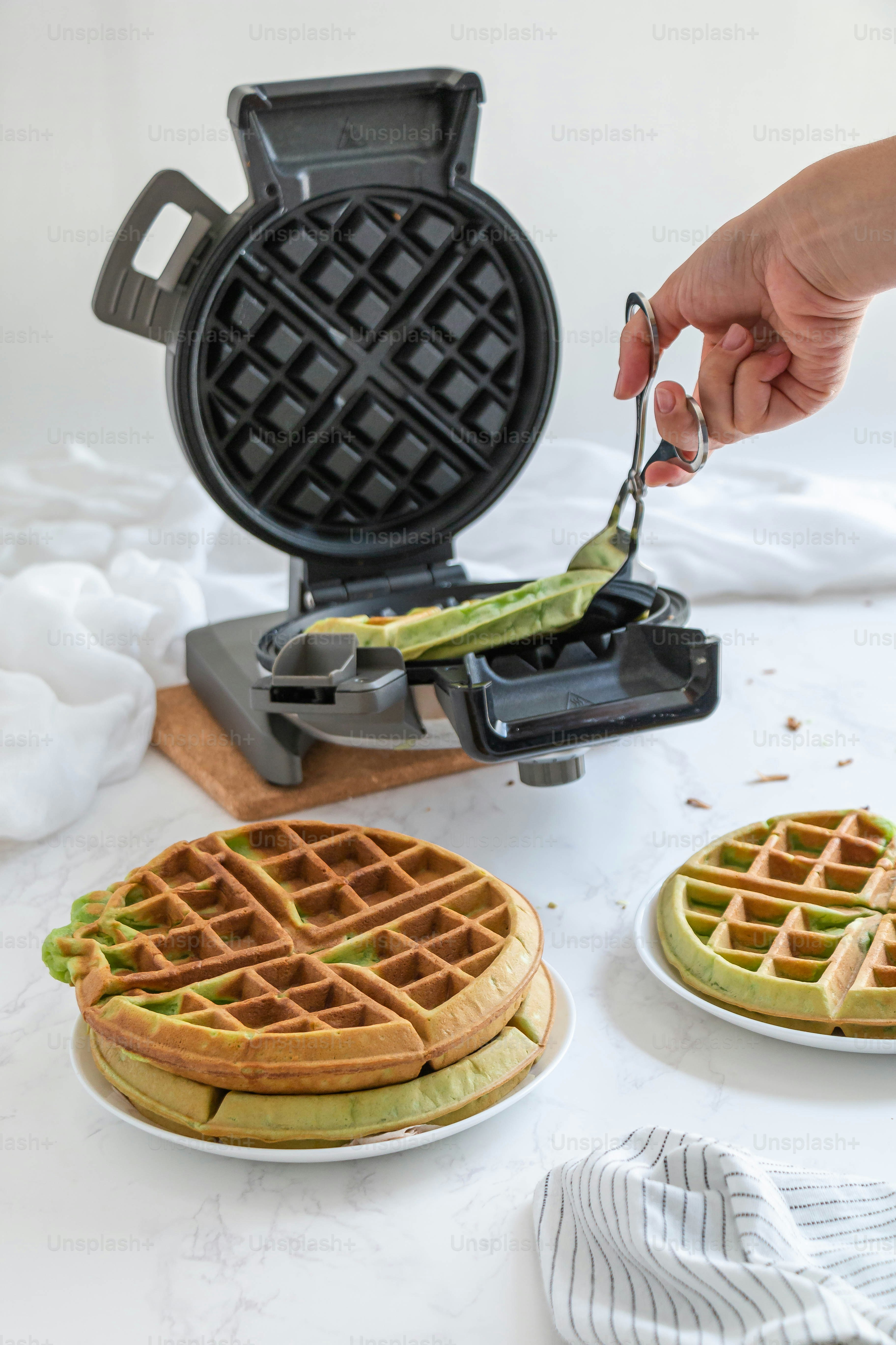 A waffle being cut with a knife and fork photo – Waffle maker Image on ...