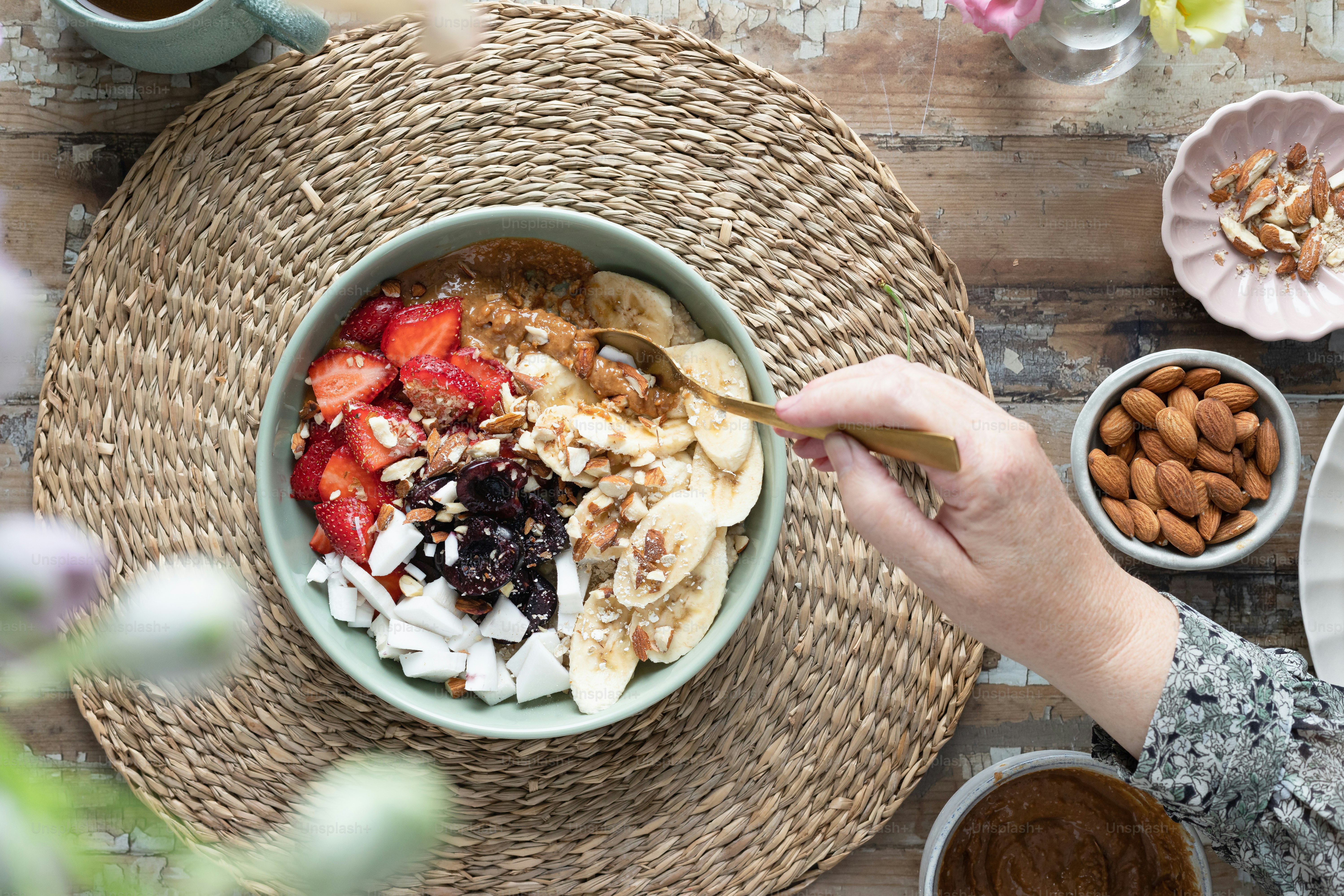 Foto Un tazón de fruta y nueces en una mesa – Alimento Imagen en Unsplash