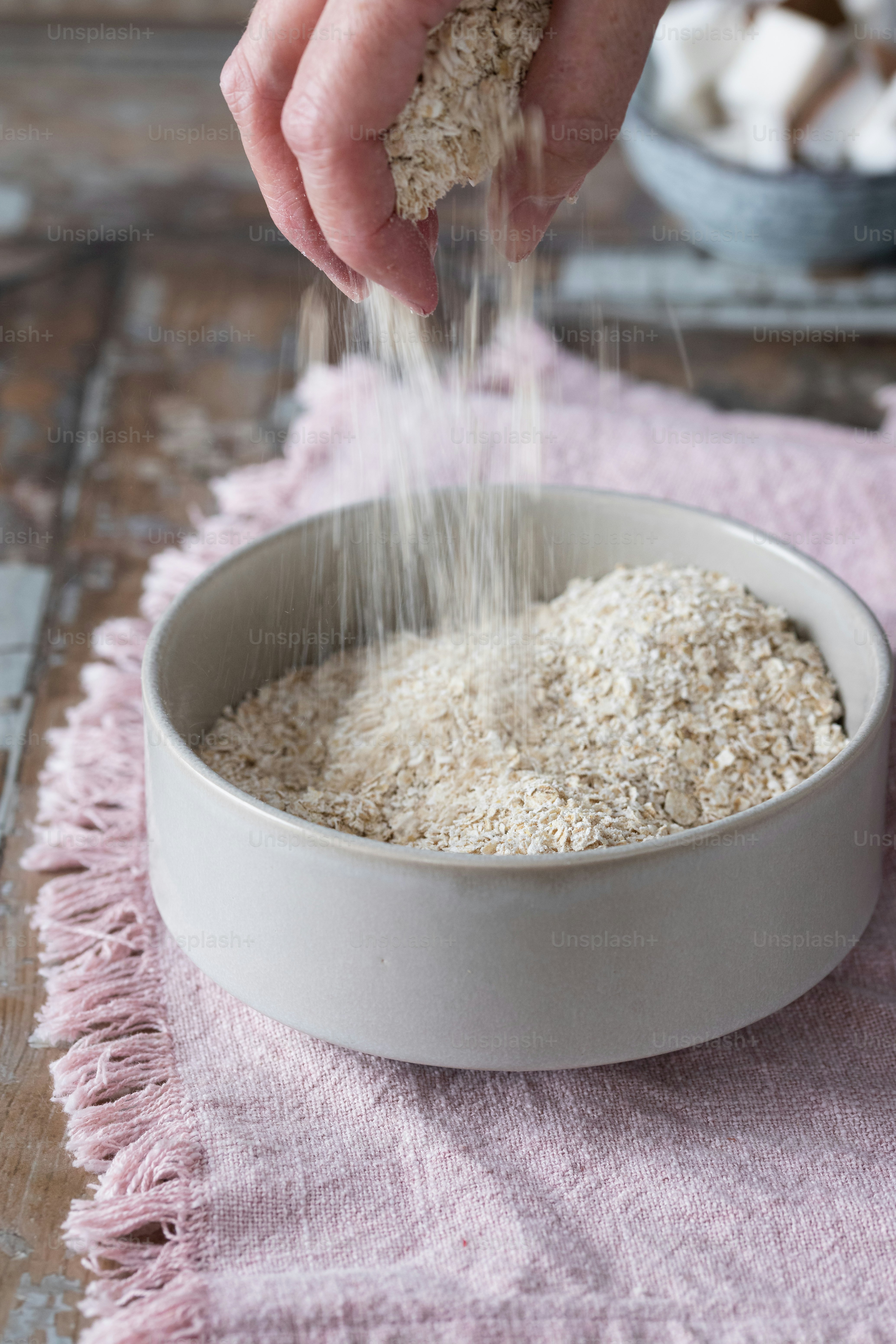 A person is sprinkling rice into a bowl photo – Porridge Image on Unsplash