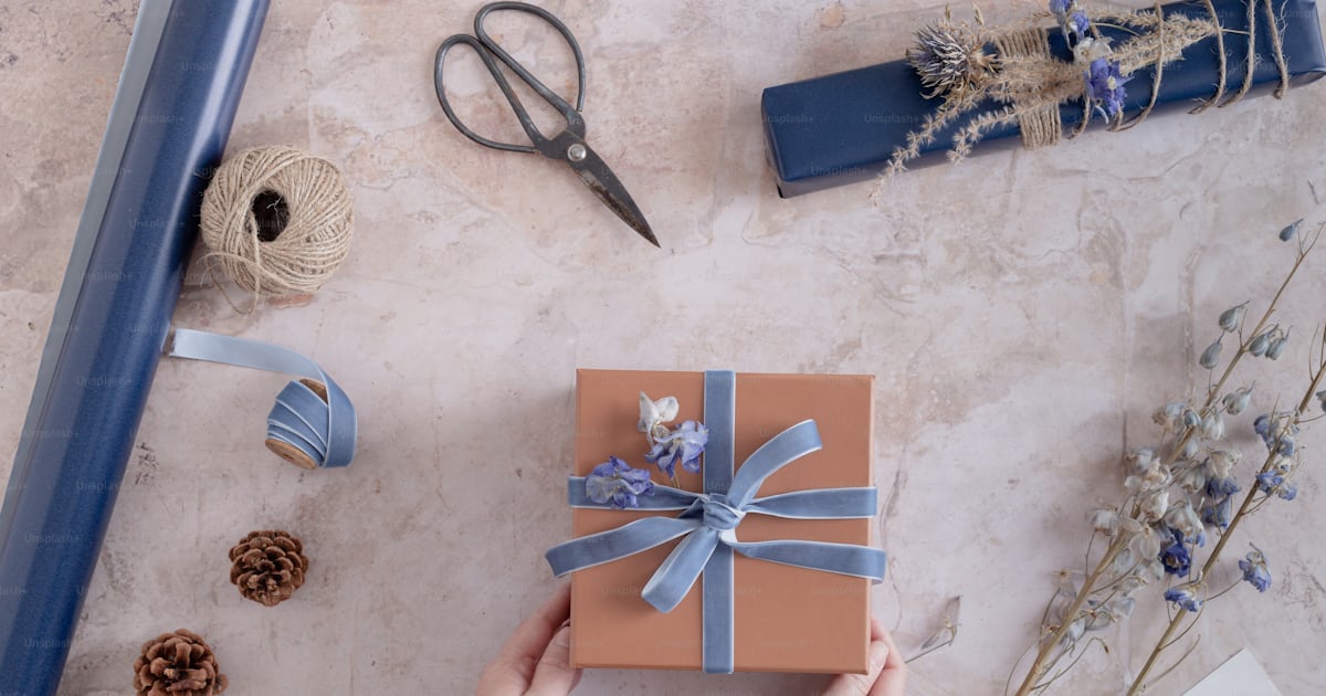 Foto zum Thema Eine Person, die eine verpackte Geschenkbox mit einem ... Foto zum Thema Eine Person, die eine verpackte Geschenkbox mit einem ...
