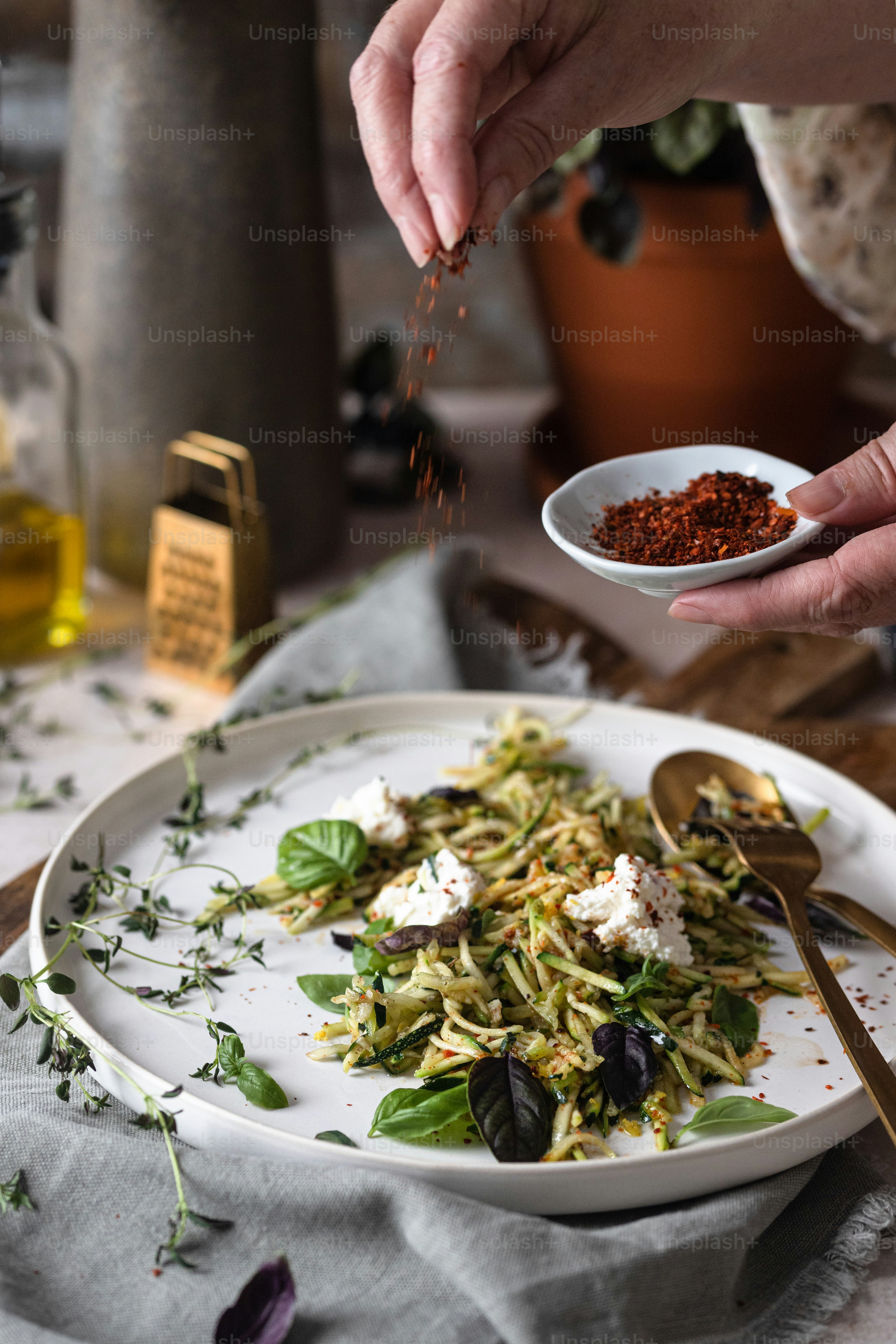 A person is sprinkling spices onto a plate of food photo – Healthy meal ...