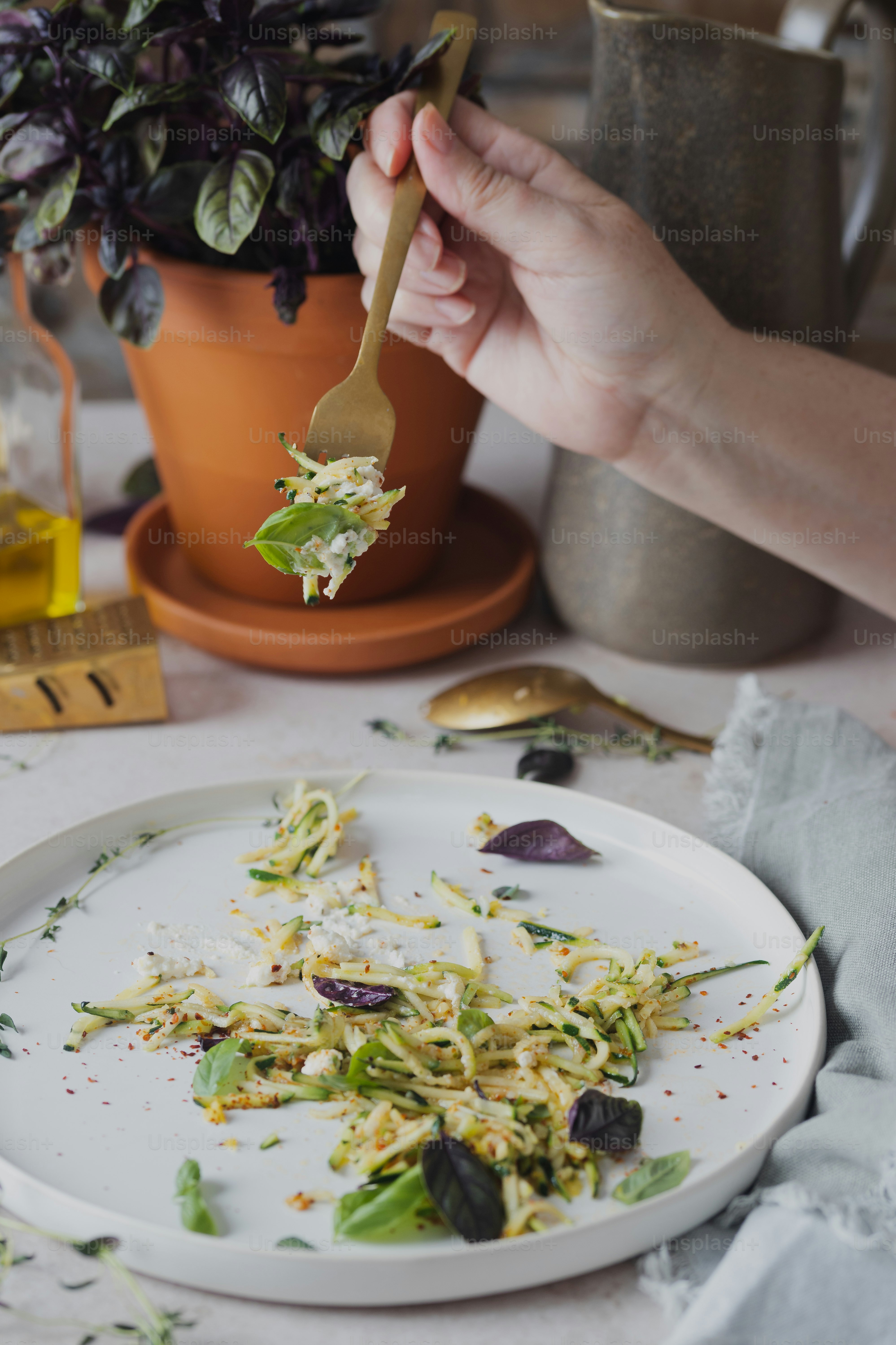 A white plate topped with lots of food next to a potted plant photo ...