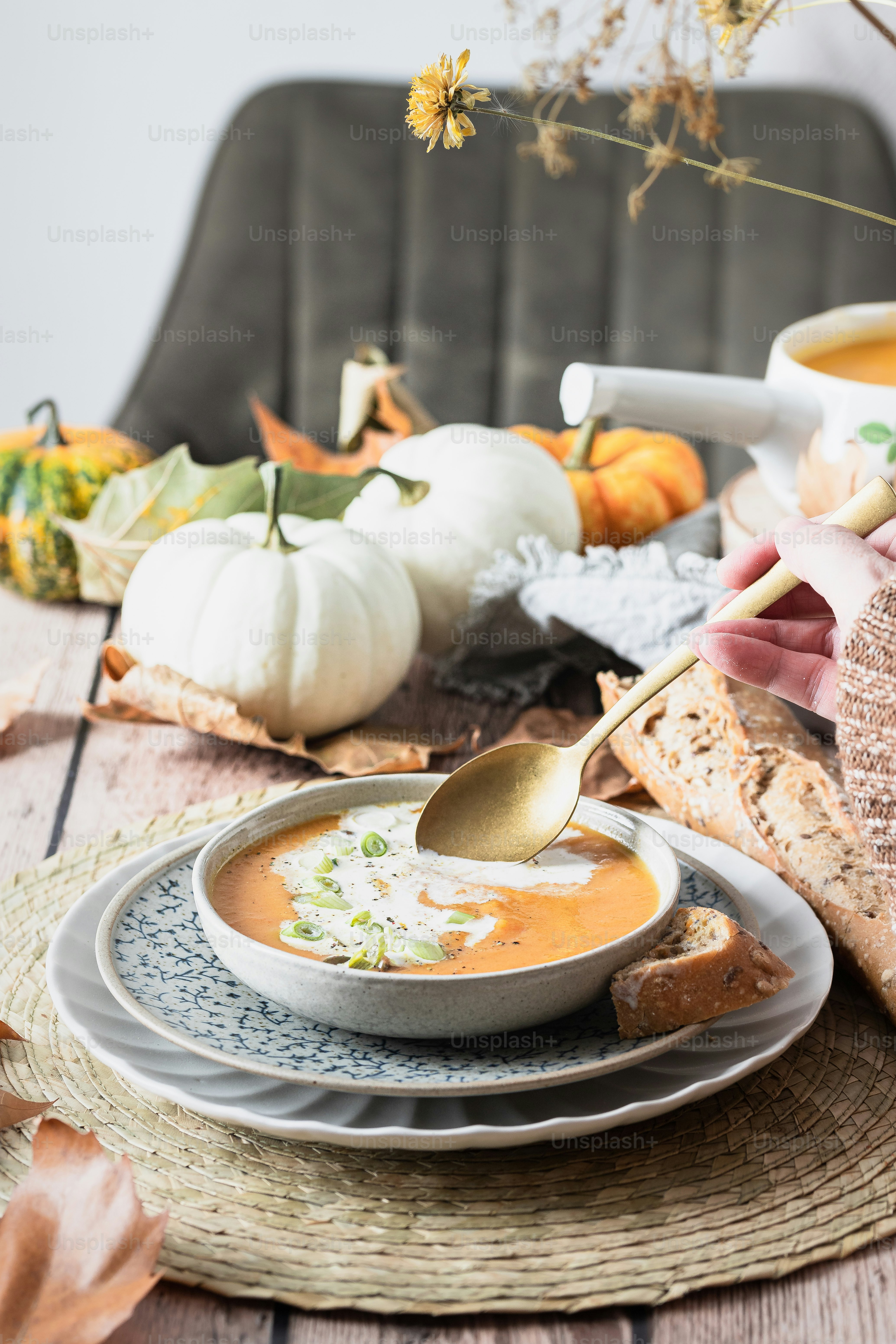 Foto Un plato de sopa en un plato con una cuchara – Sopa de calabaza ...