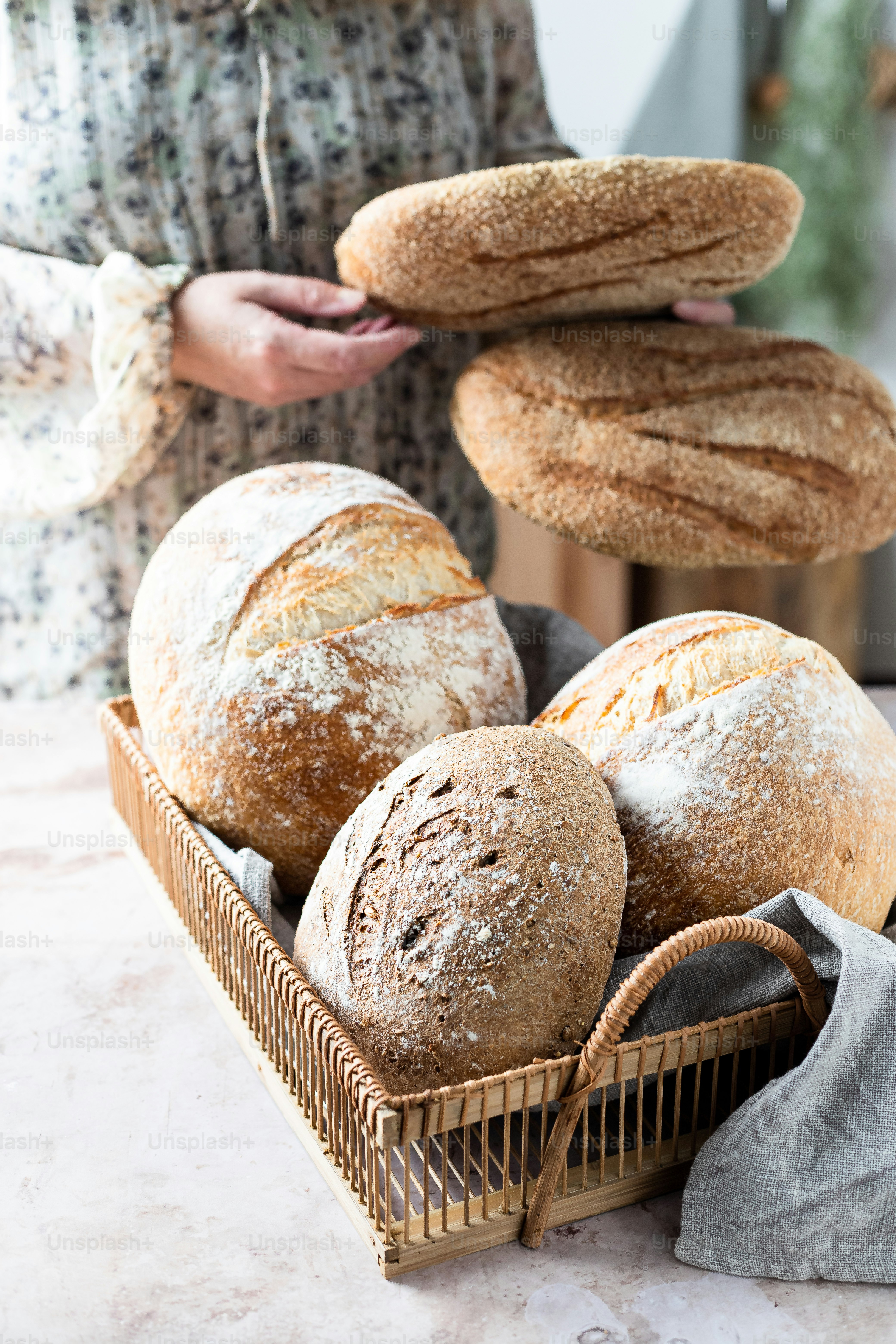 A woman holding a basket of loaves of bread photo – Bread Image on Unsplash