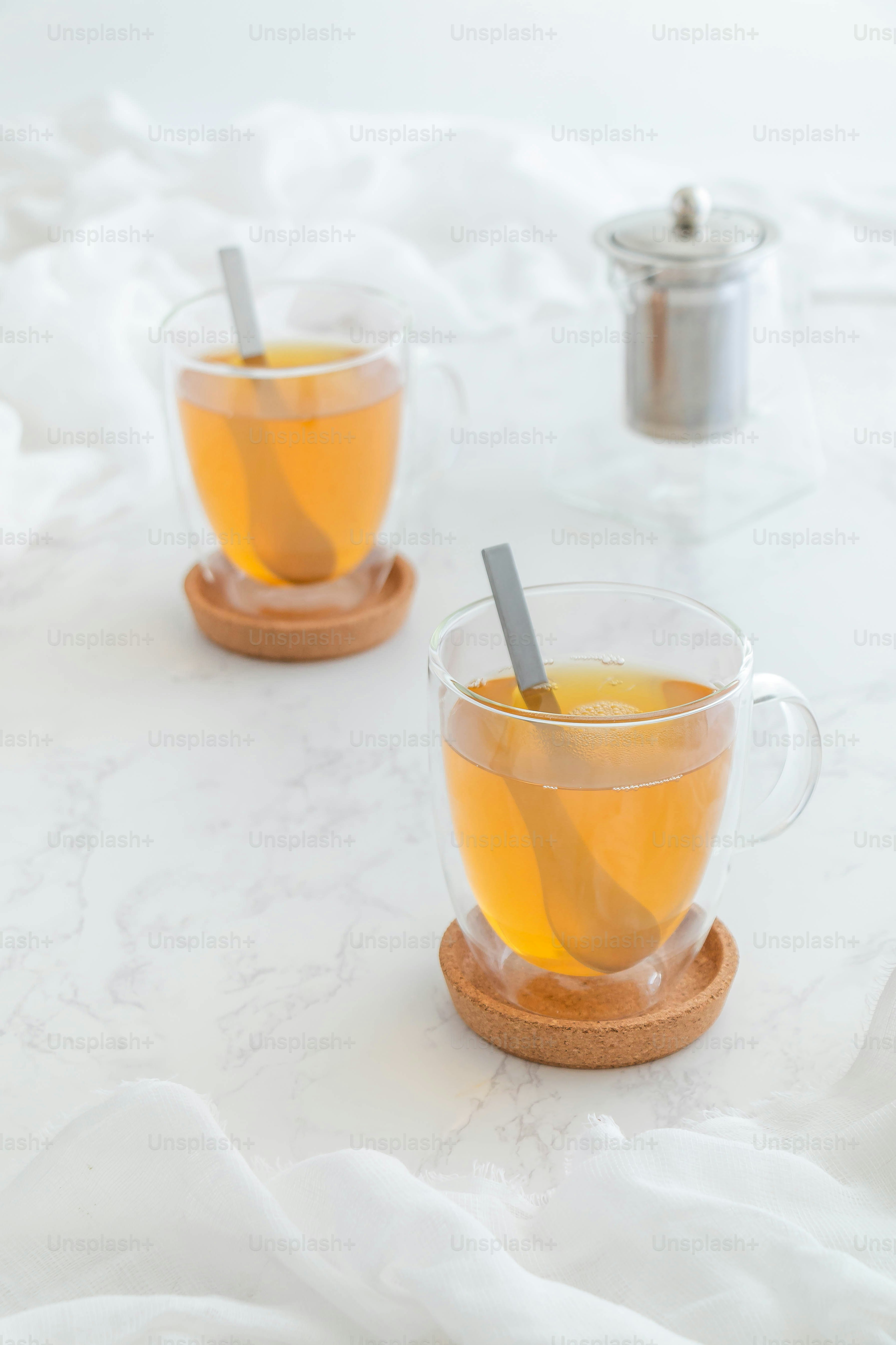 Two cups of tea with a spoon in them photo – Herbal tea Image on Unsplash