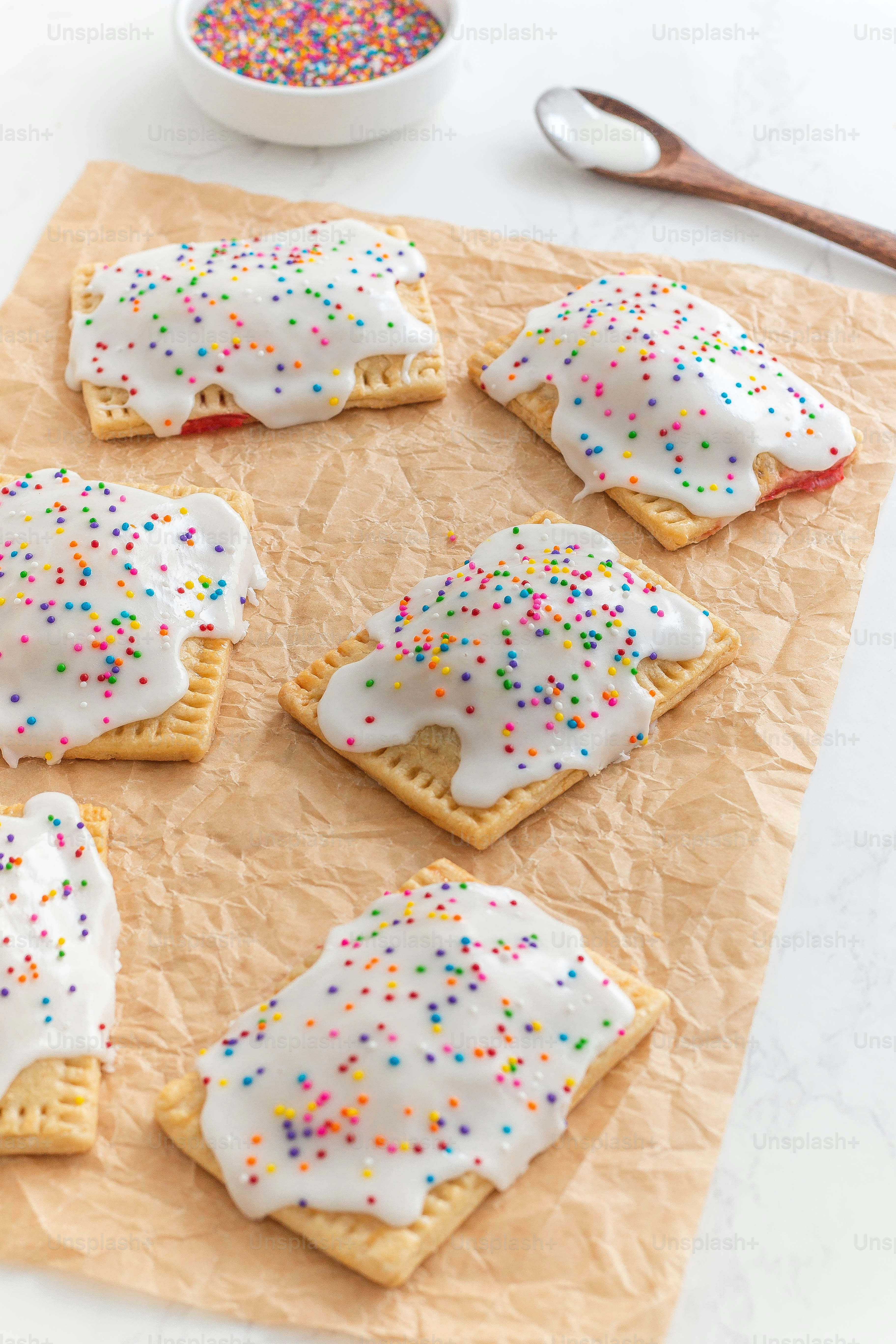 A table topped with cookies covered in frosting and sprinkles photo ...