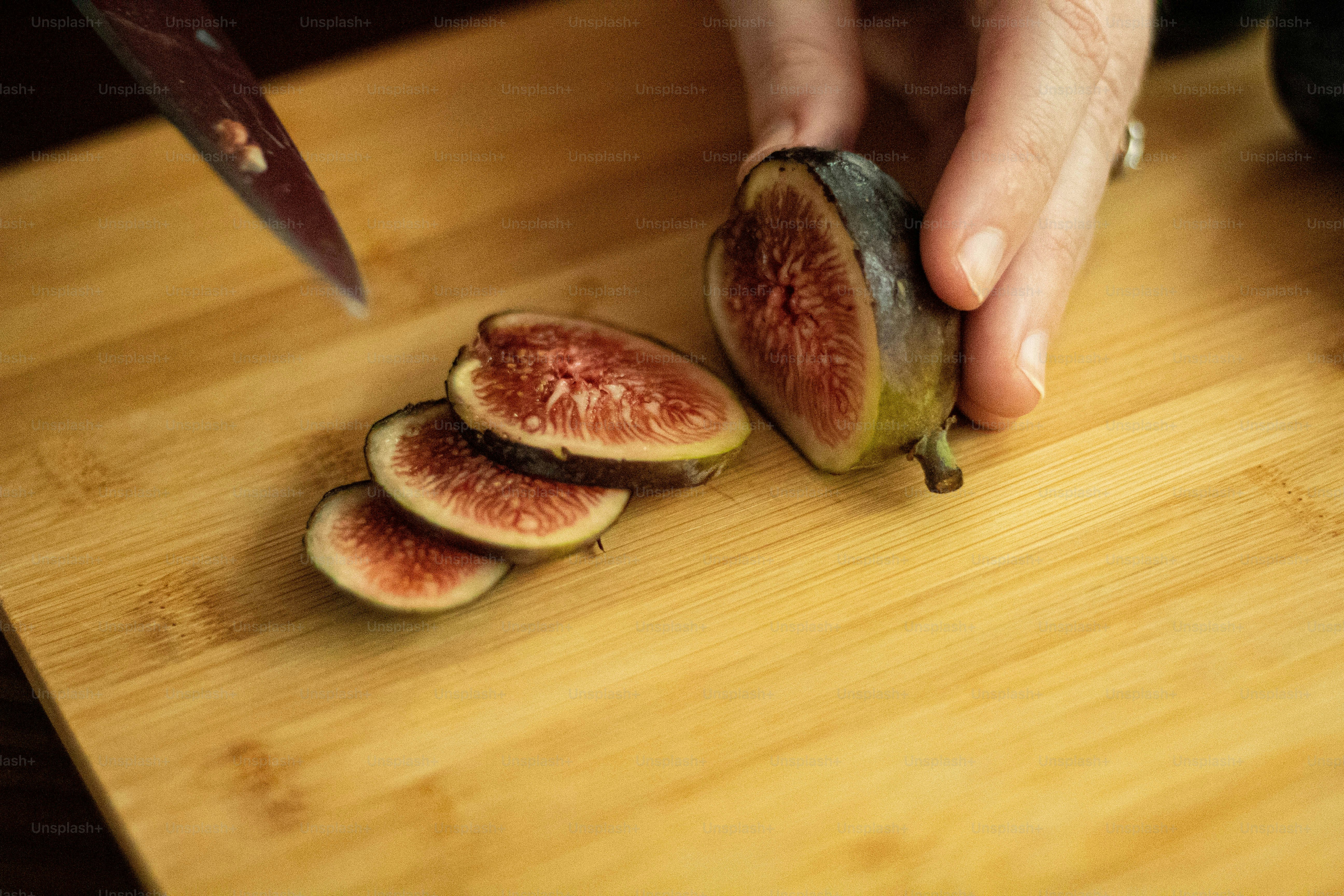 A person cutting up a piece of fruit on a cutting board photo – Slicing ...