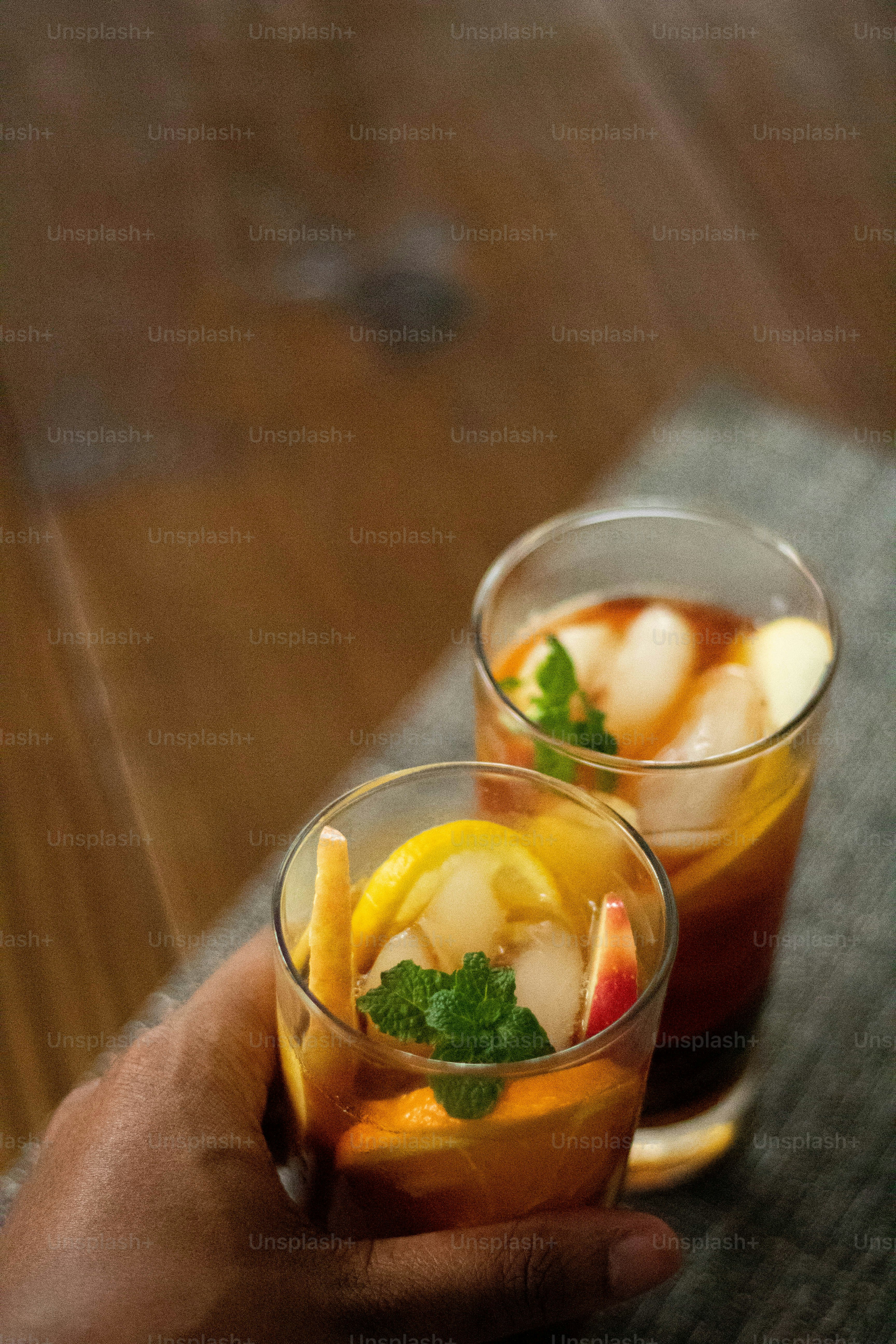 A person holding a glass of iced tea photo – Apple cider Image on Unsplash