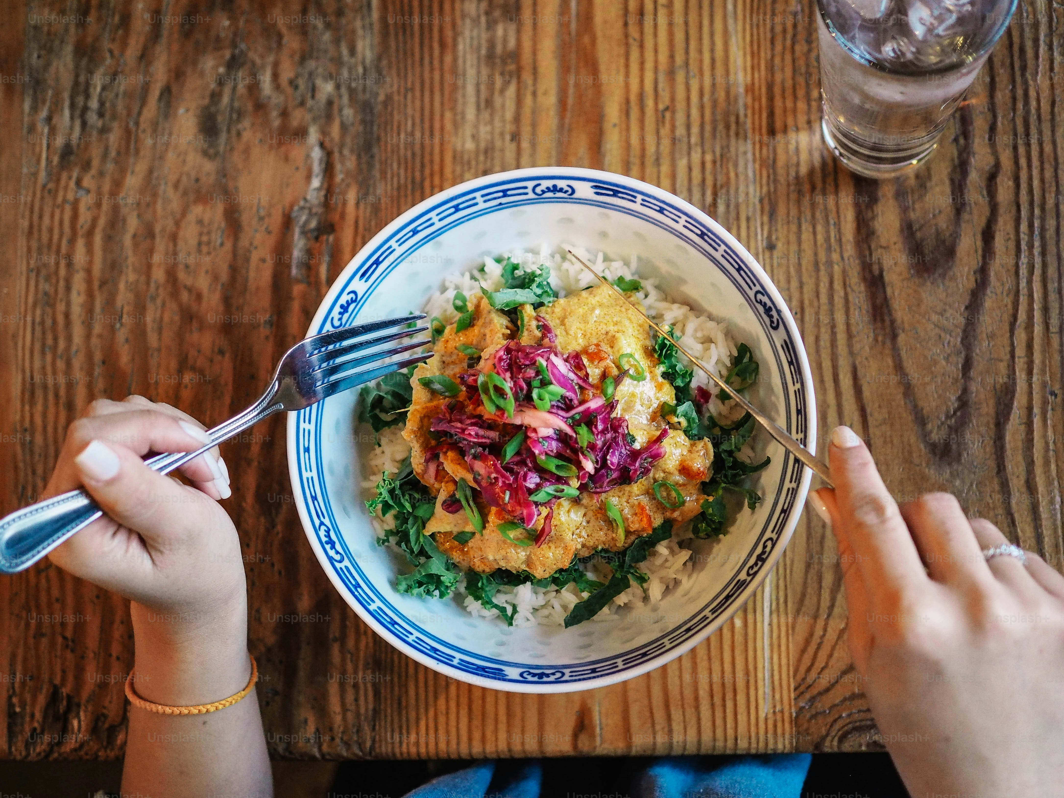 Una persona está comiendo un plato de comida en una mesa foto – Imagen ...