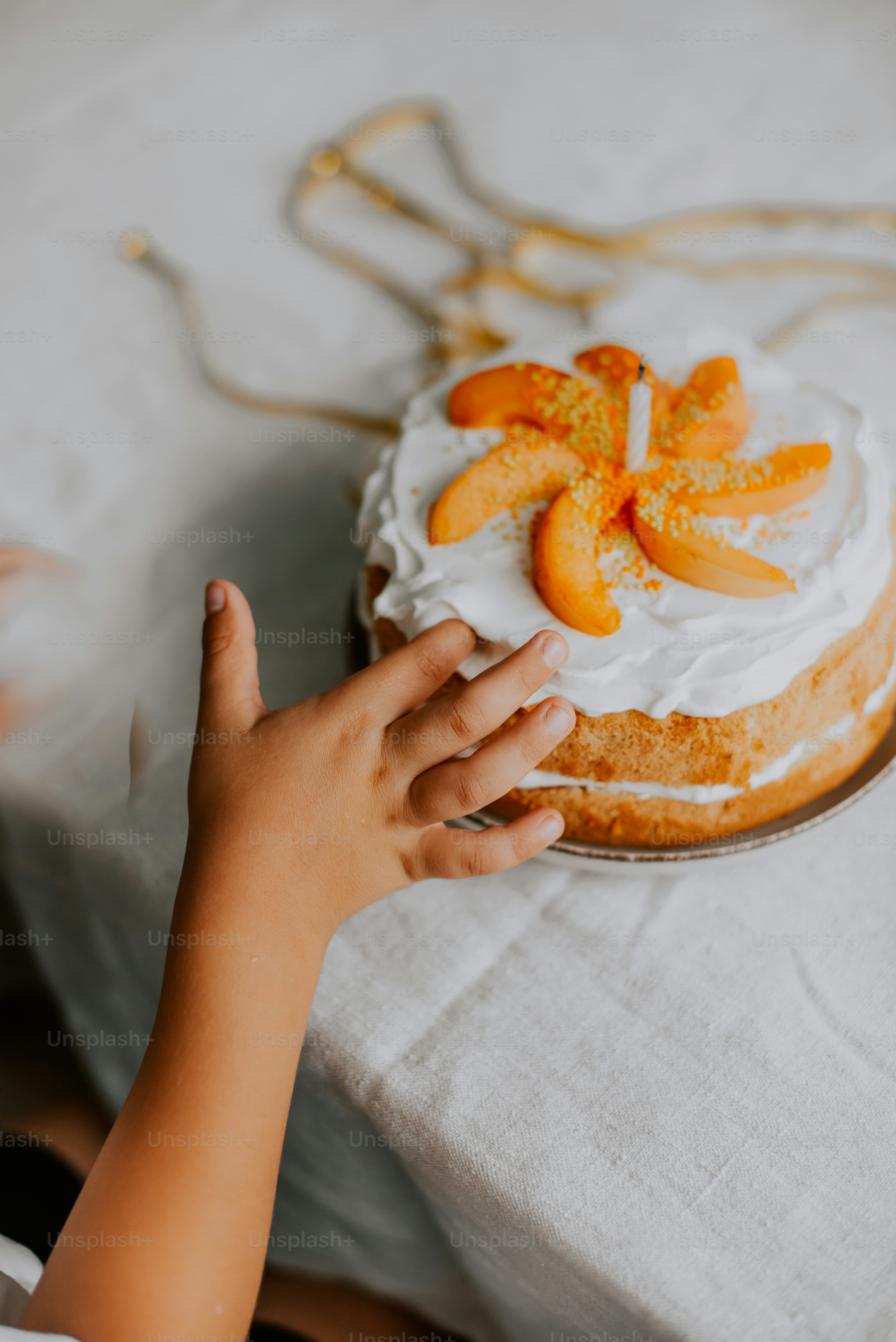 A child reaching for a piece of cake on a table photo – Dessert Image ...