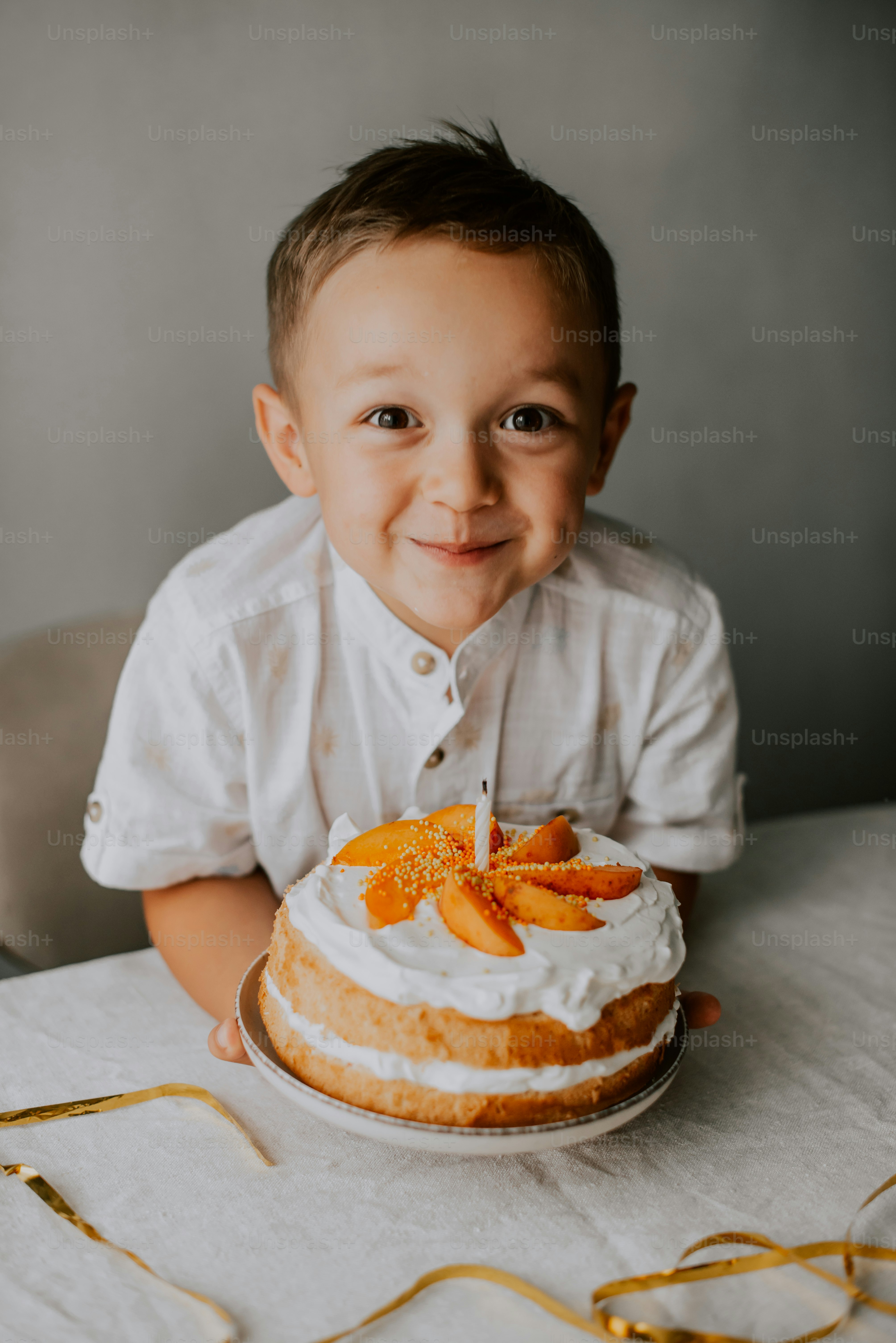 A little boy that is sitting in front of a cake photo – Dessert Image ...
