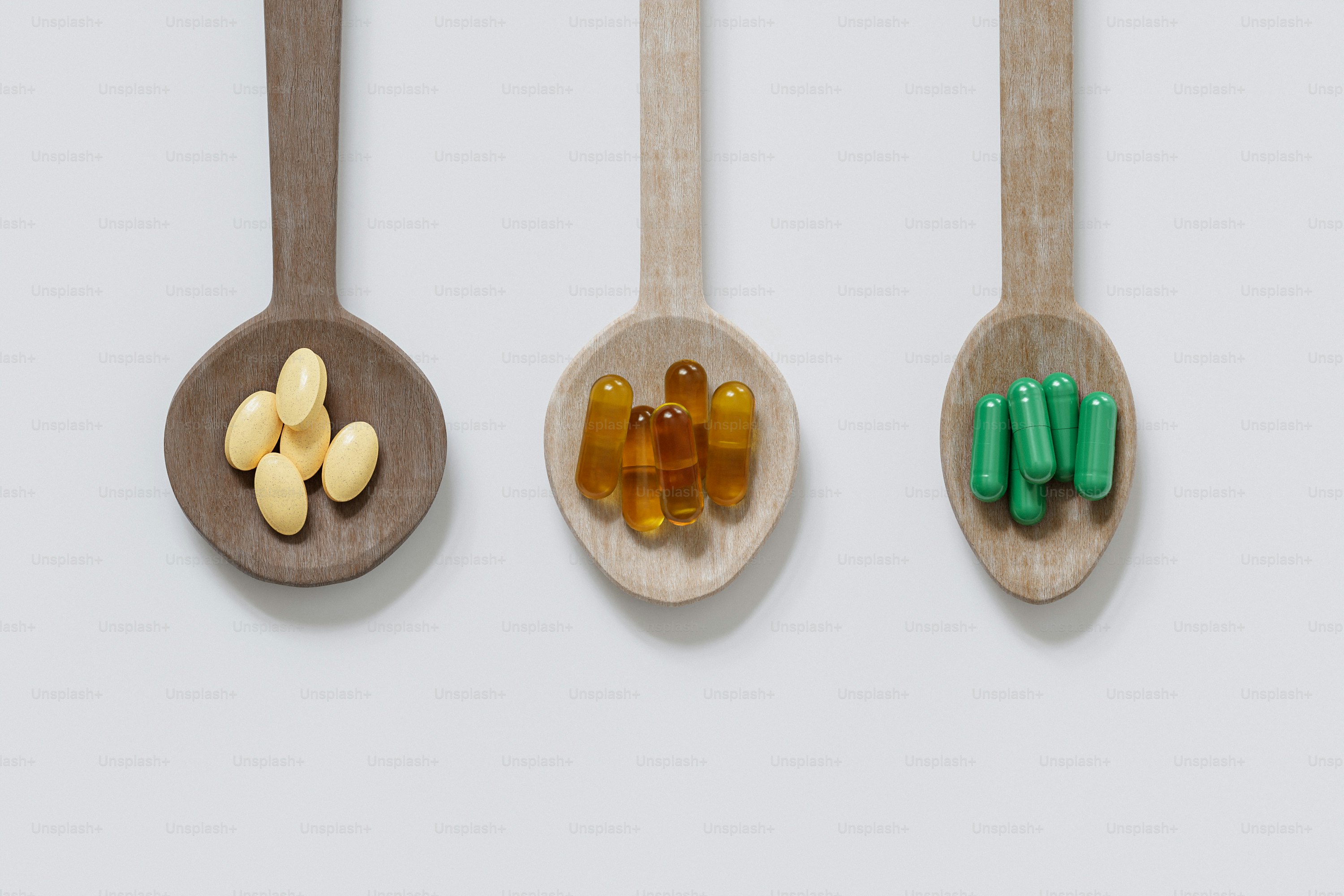 Three wooden spoons with different colored pills in them photo – Drugs ...