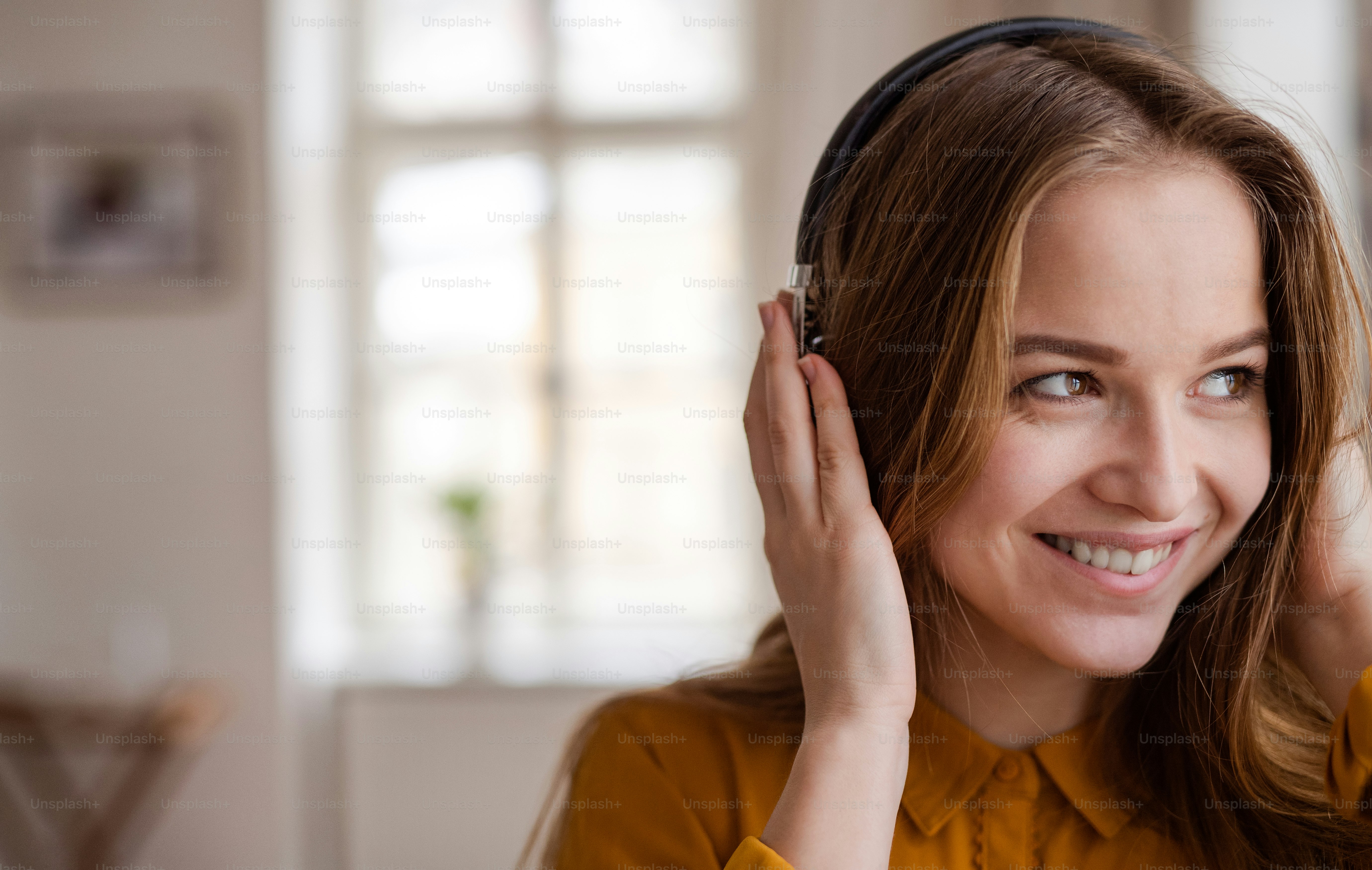 A close-up portrait of happy young female student standing indoors ...