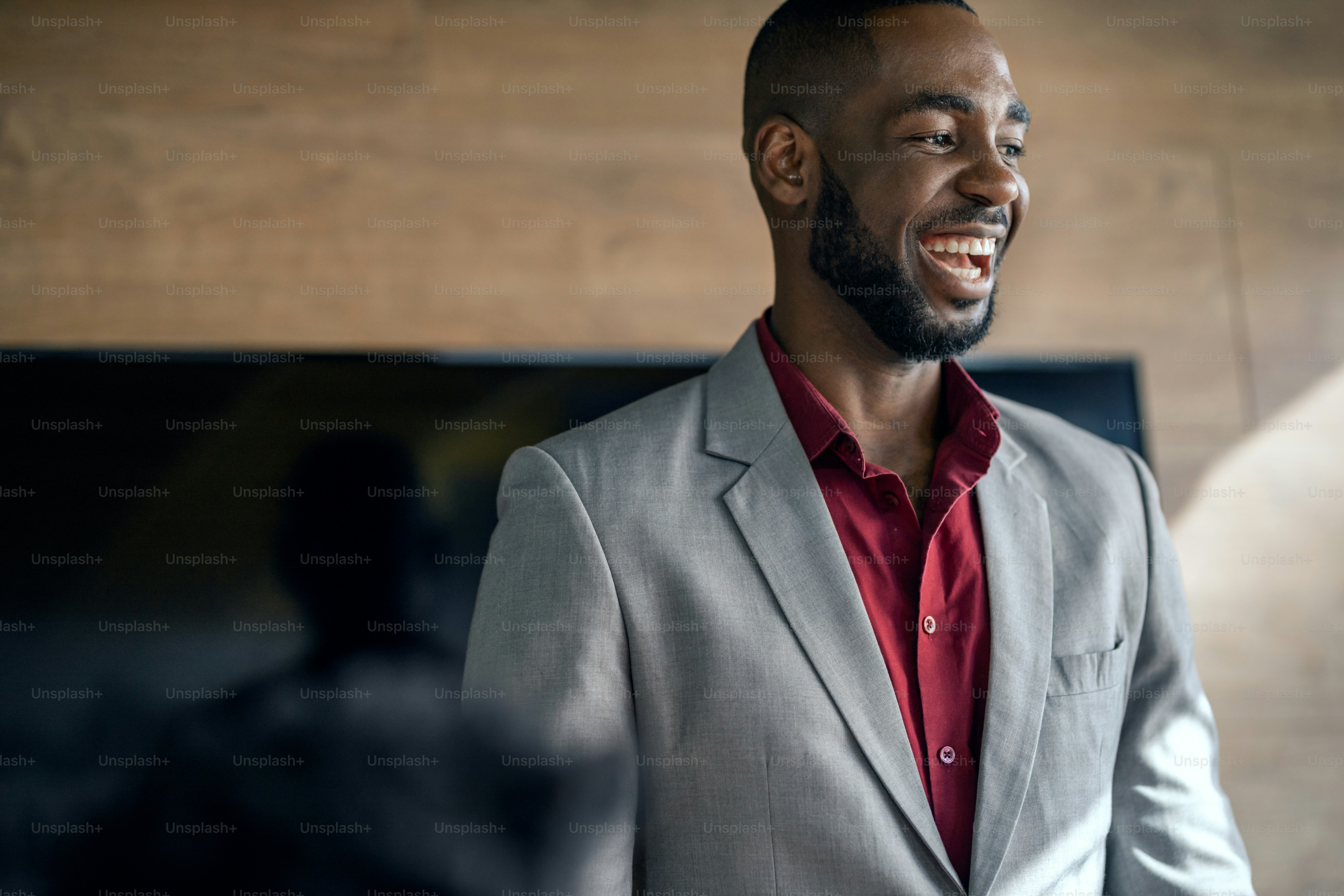 Jeune manager africain riant en discutant avec son personnel lors d’une ...