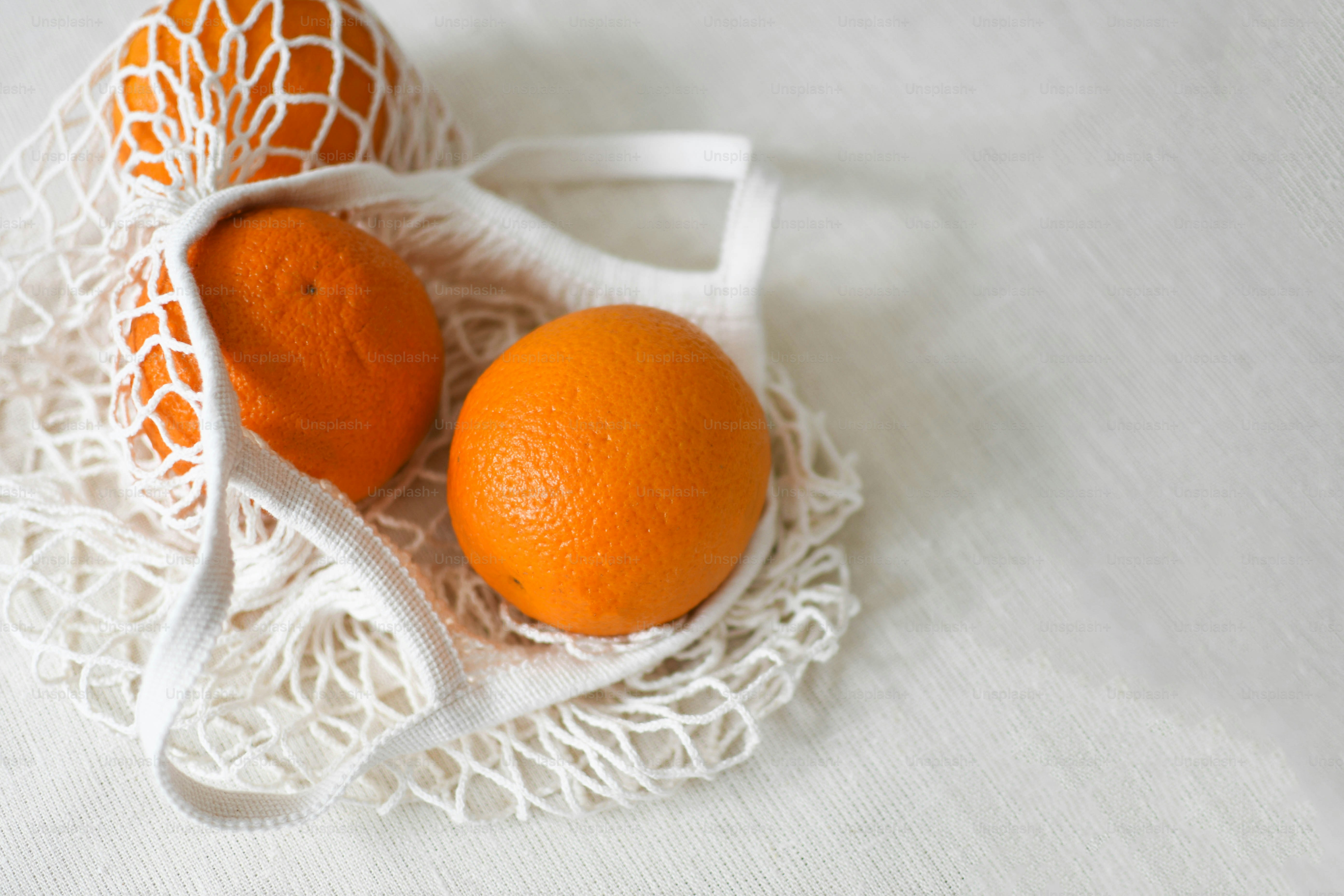 Deux oranges dans un sac blanc sur un tissu blanc photo – Image de ...