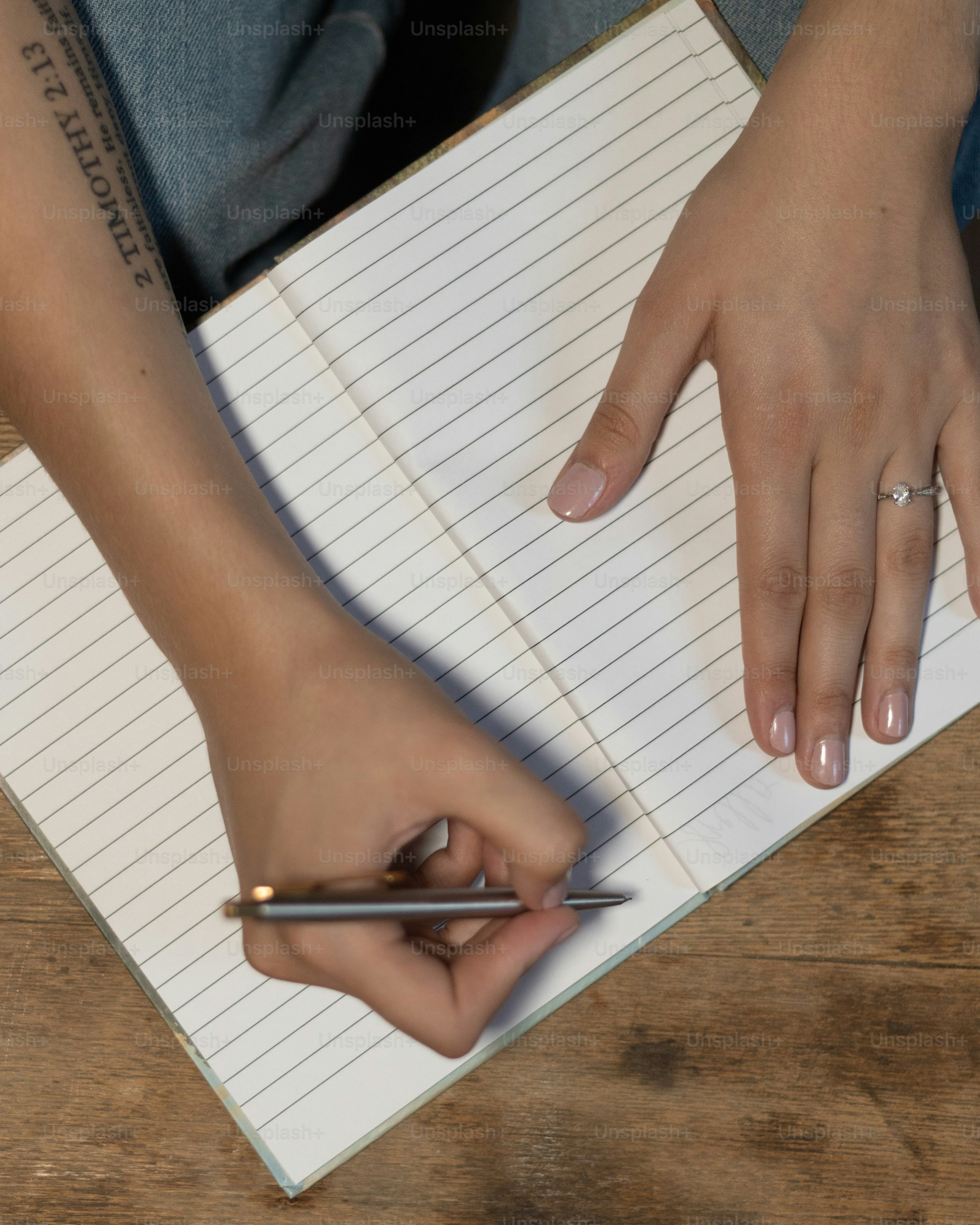 A person holding a pen and writing on a notebook photo – Journalling ...