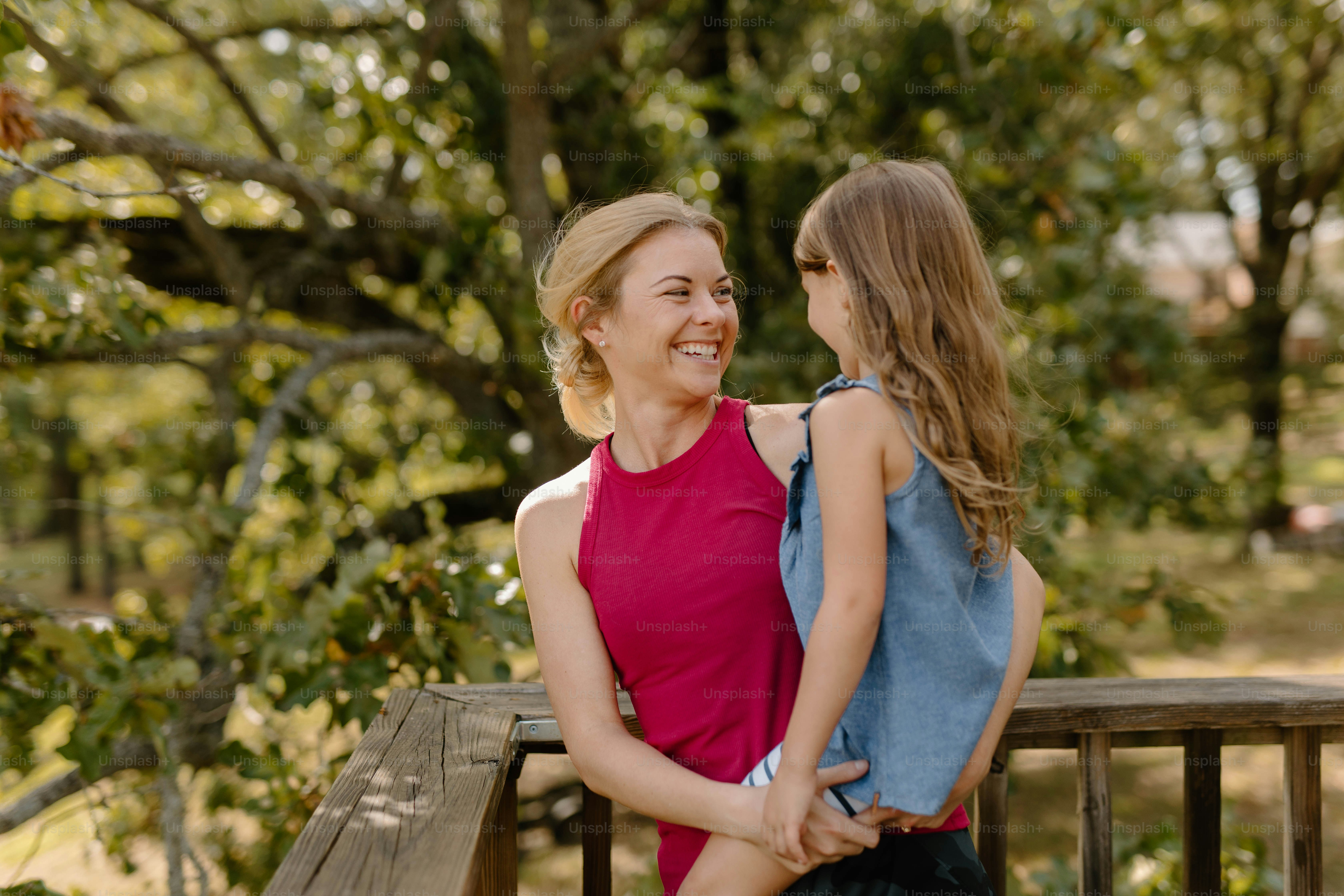 A woman hugging a little girl on a bench photo – Babysitting Image on ...
