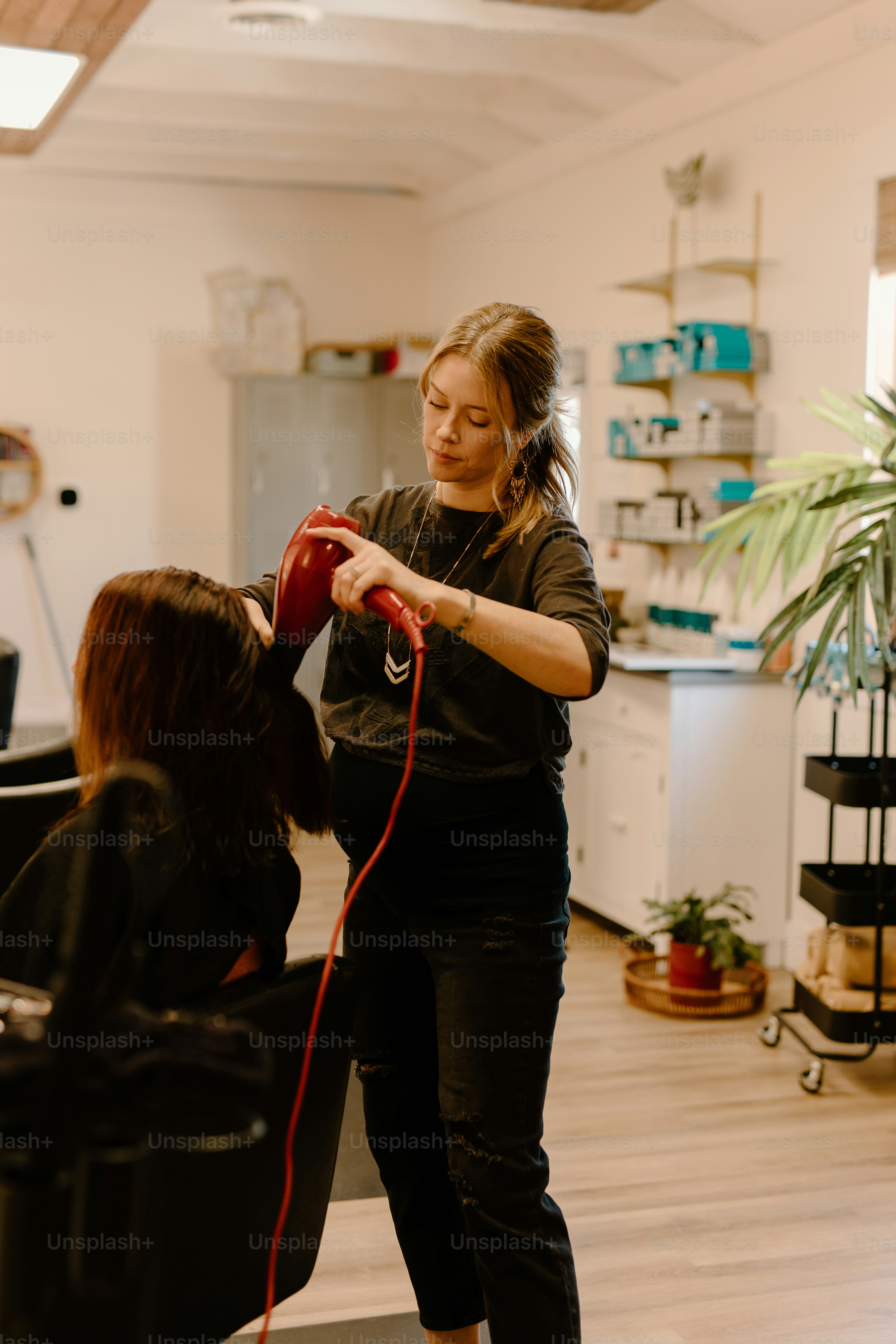 A woman getting her hair done in a salon photo – Hair stylist Image on ...