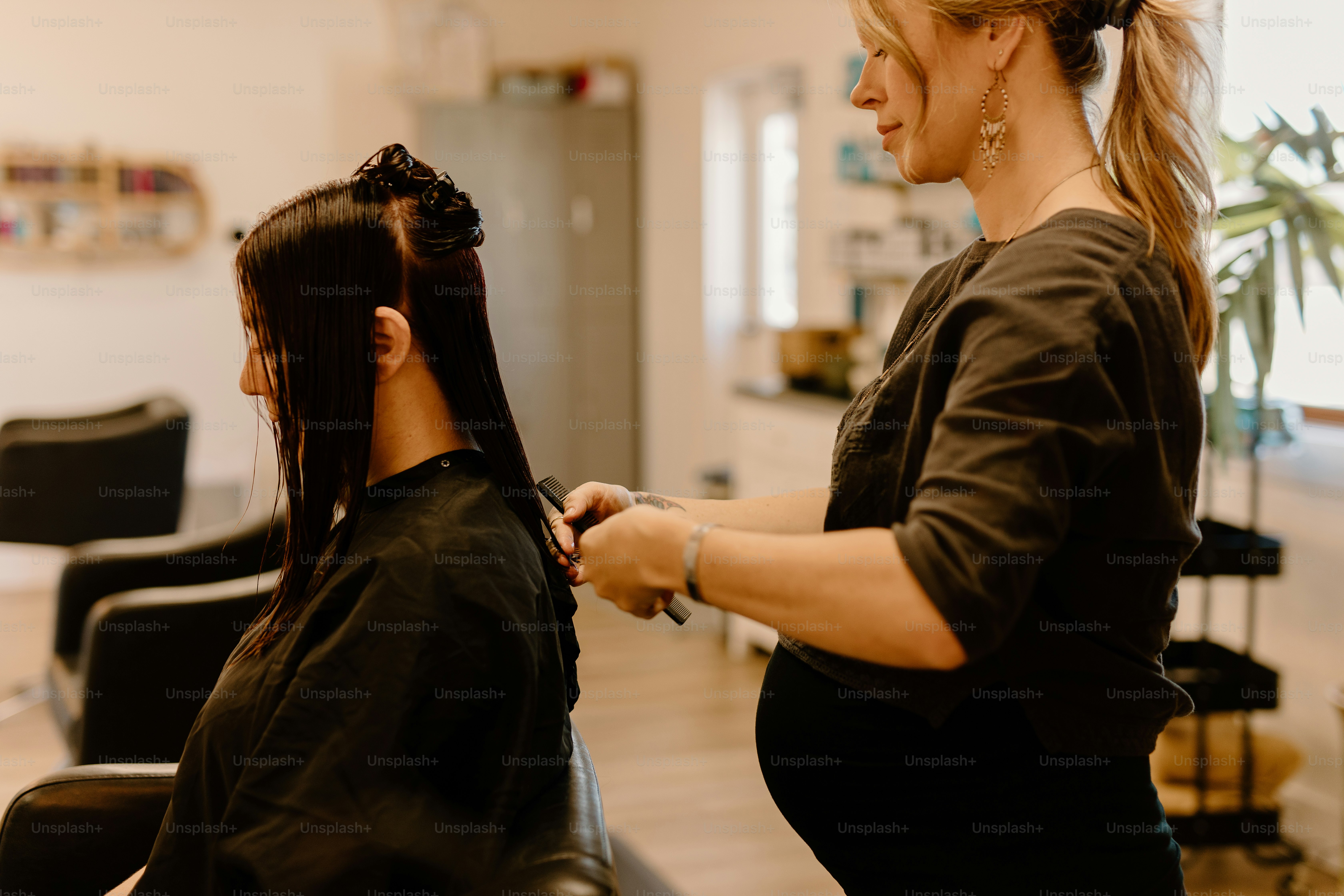 Foto Una mujer cortando el cabello de otra mujer en un salón ...