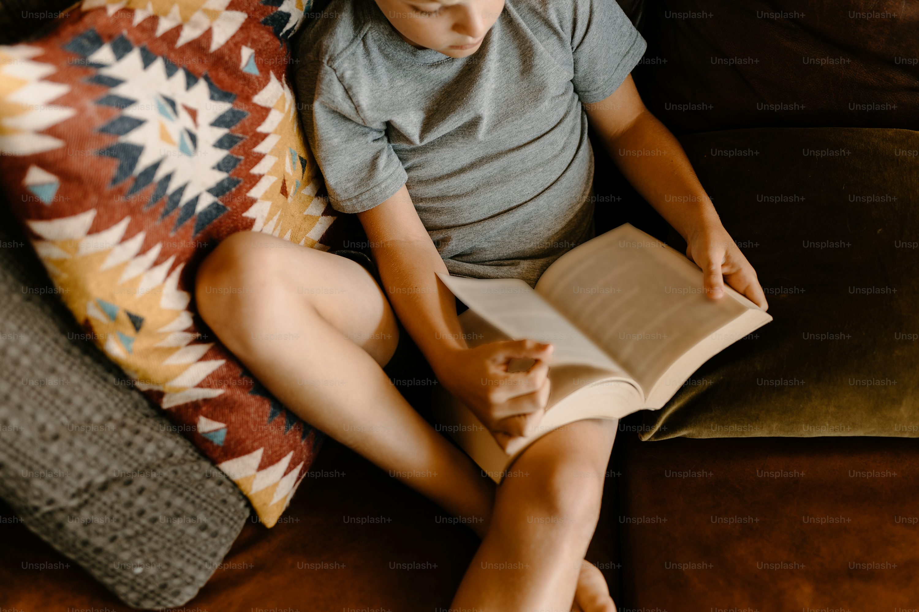 Un giovane ragazzo seduto su un divano che legge un libro foto ... Un giovane ragazzo seduto su un divano che legge un libro foto ...