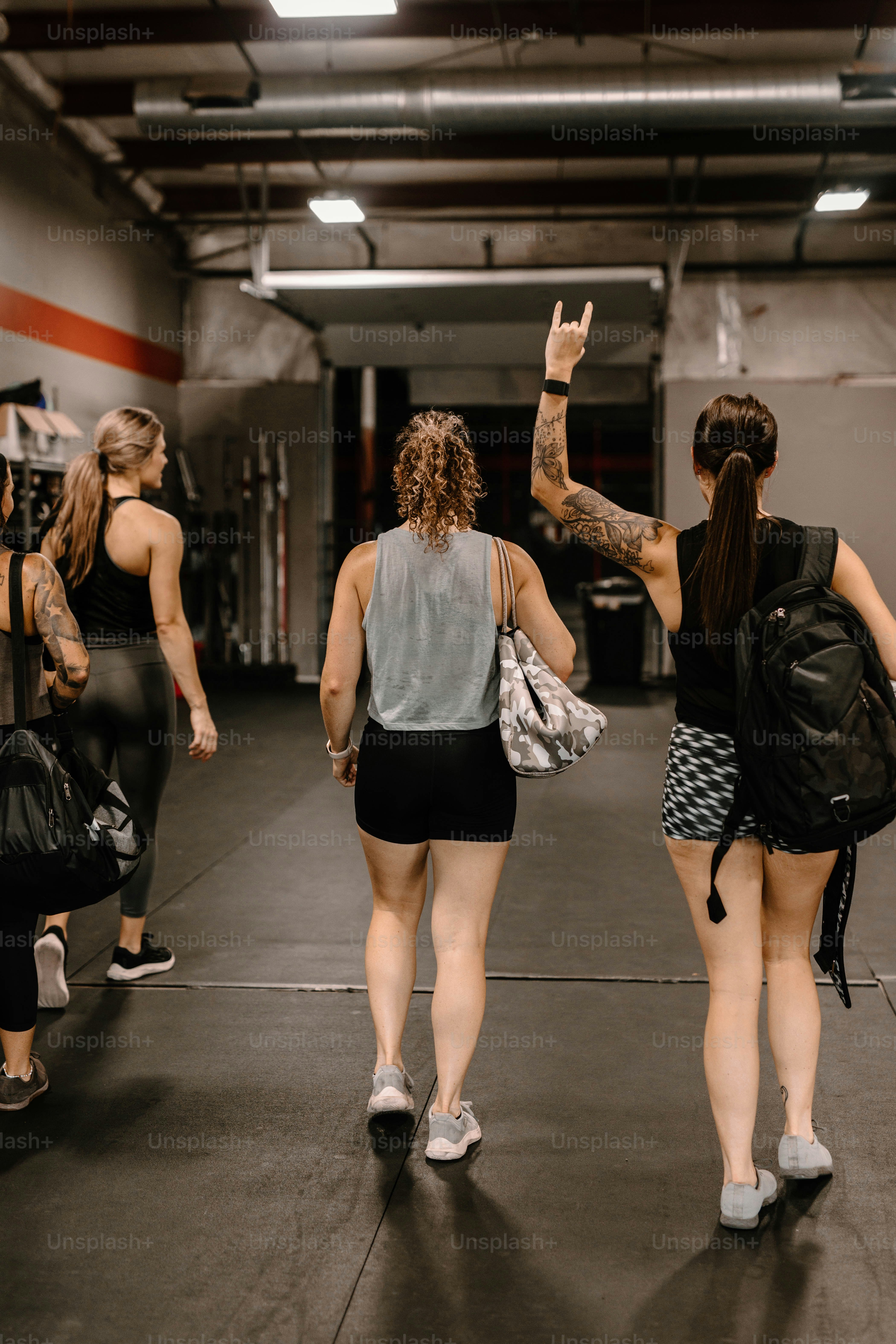 A group of women walking through a gym photo – Working out Image on ...