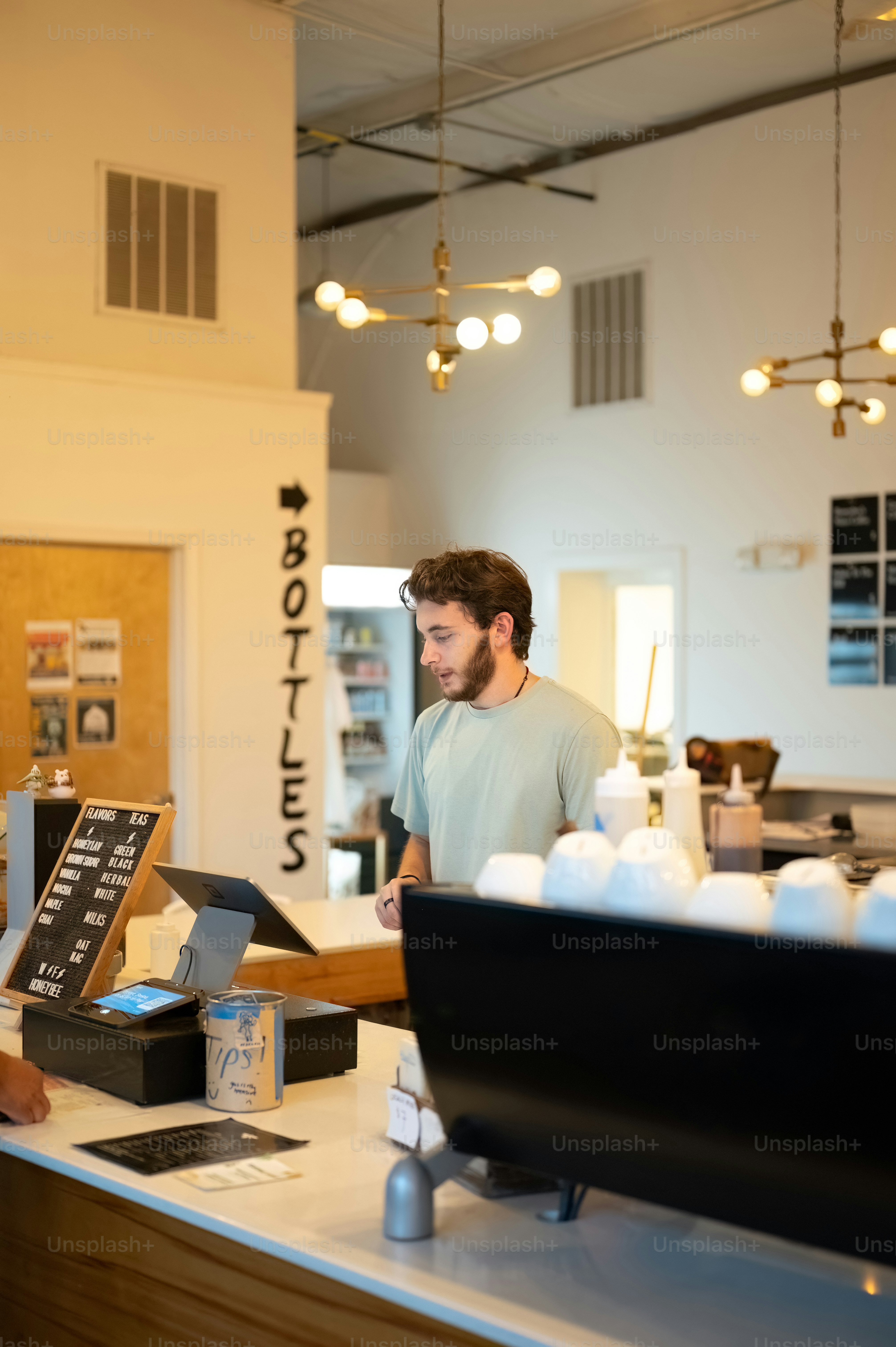 A man standing behind a counter in a store photo – Resturant Image on ...