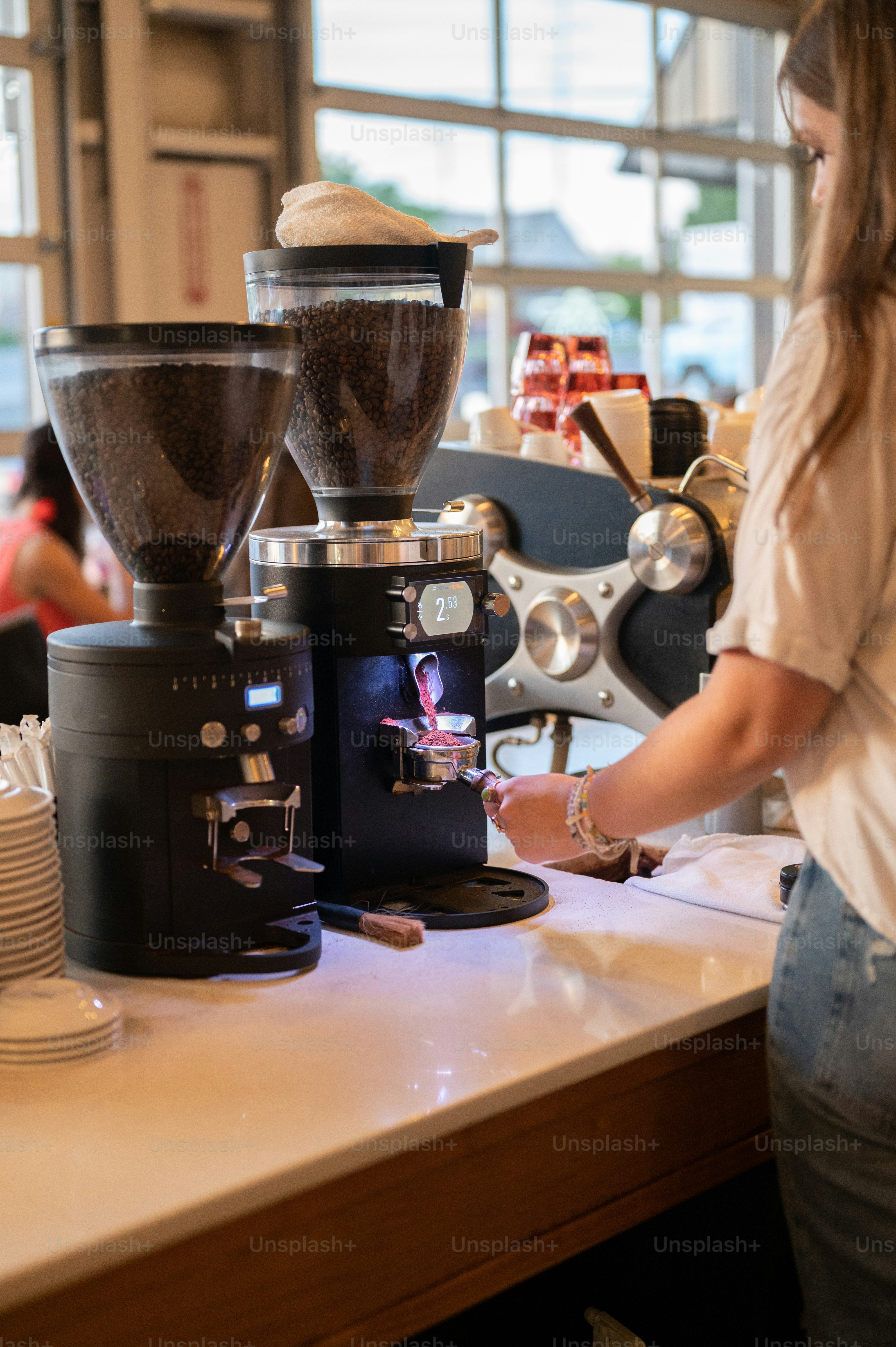 A woman standing in front of a coffee machine photo – Coffee grinder ...