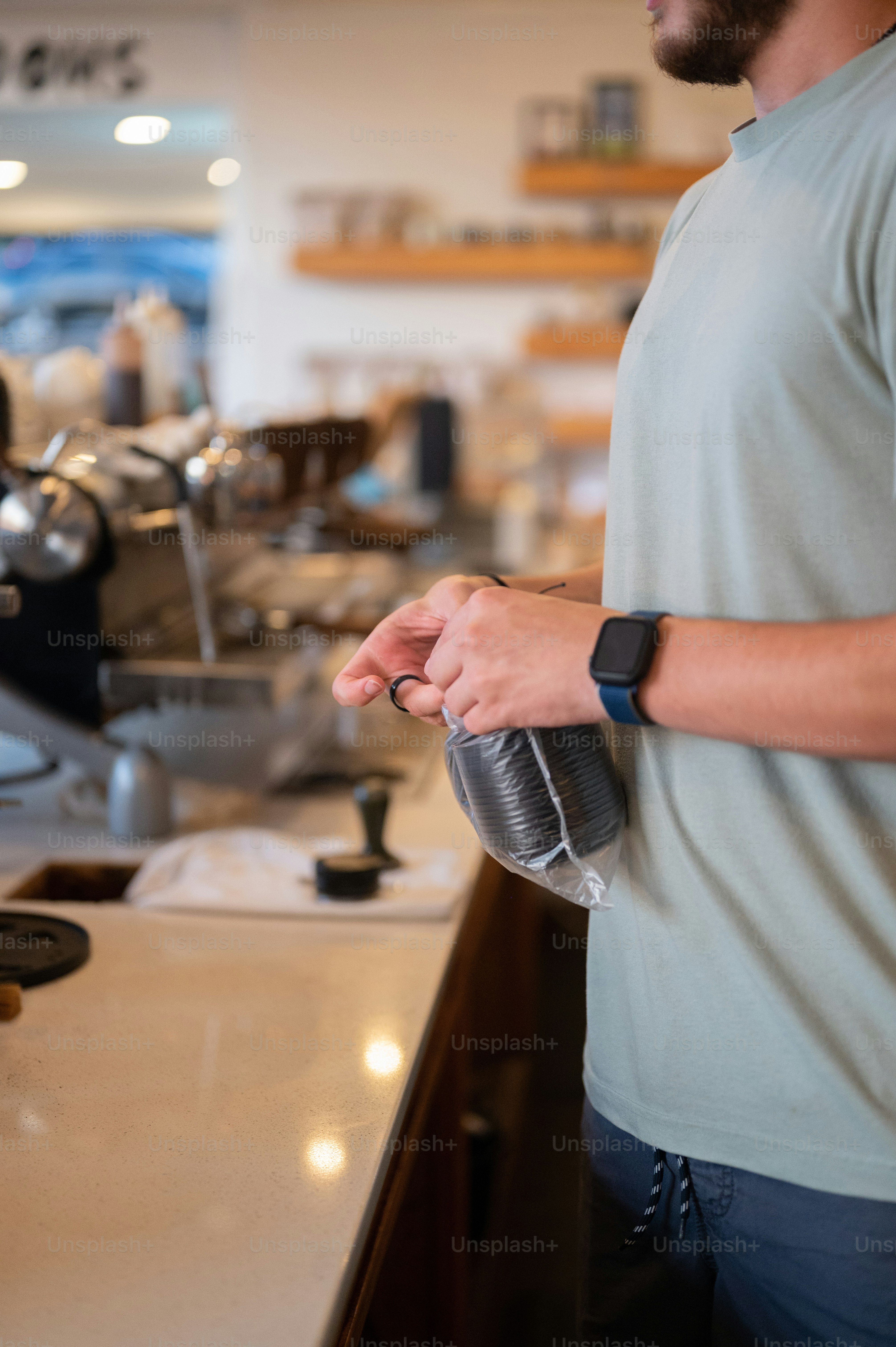 A man standing behind a counter in a store photo – Resturant Image on ...