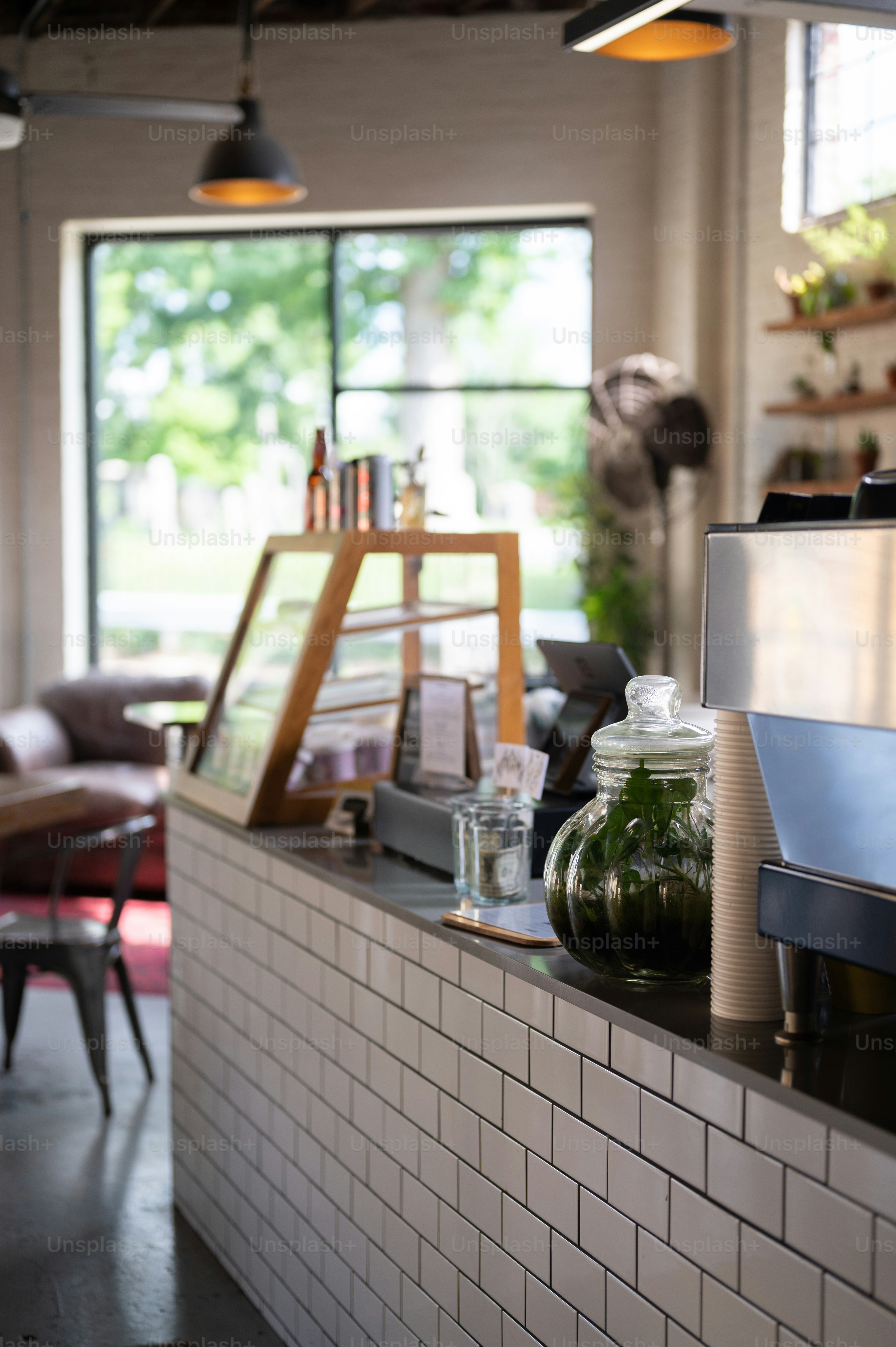 Una cafetería con un mostrador largo y una ventana grande foto – Imagen ...