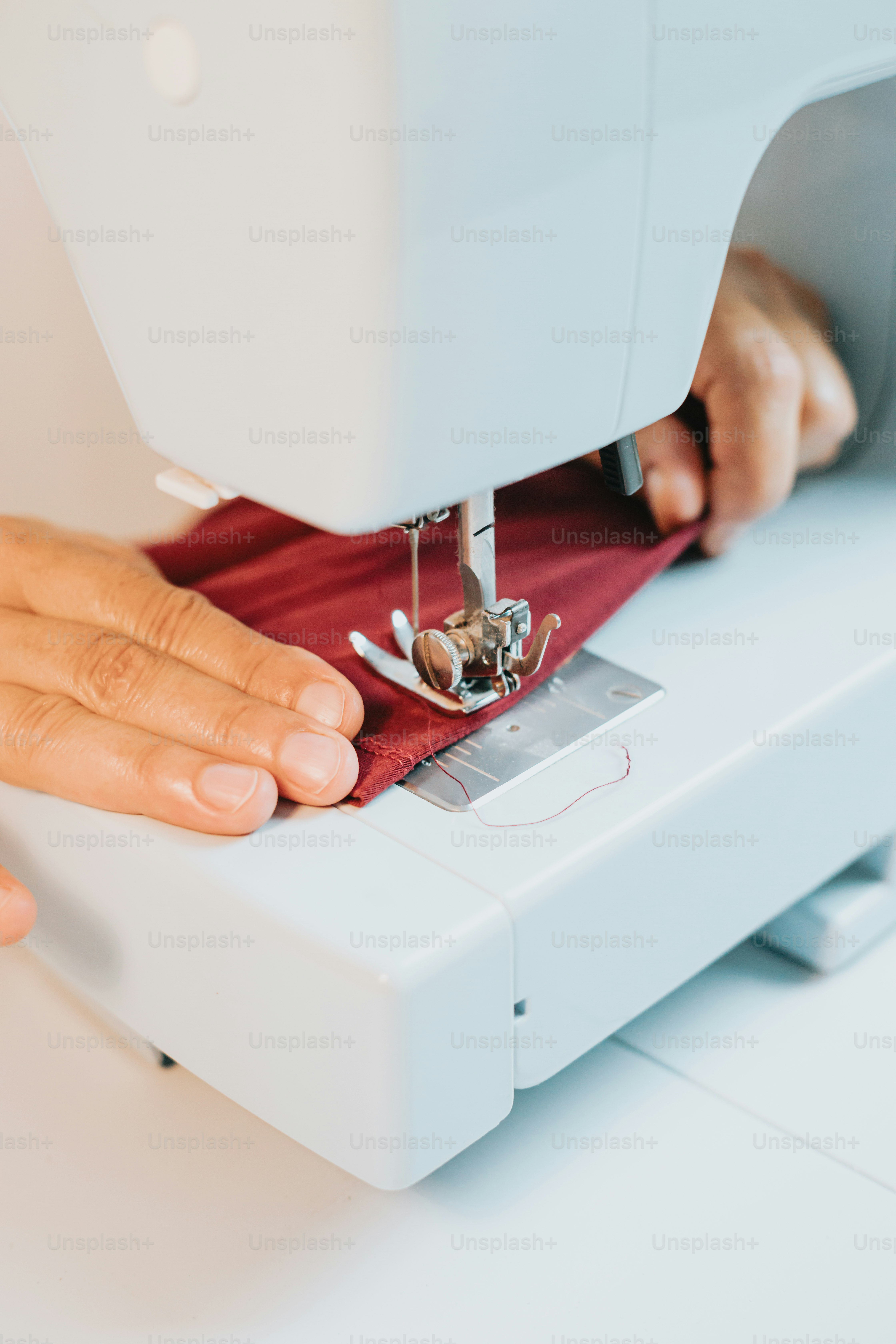 A person using a sewing machine to sew a piece of fabric photo ...