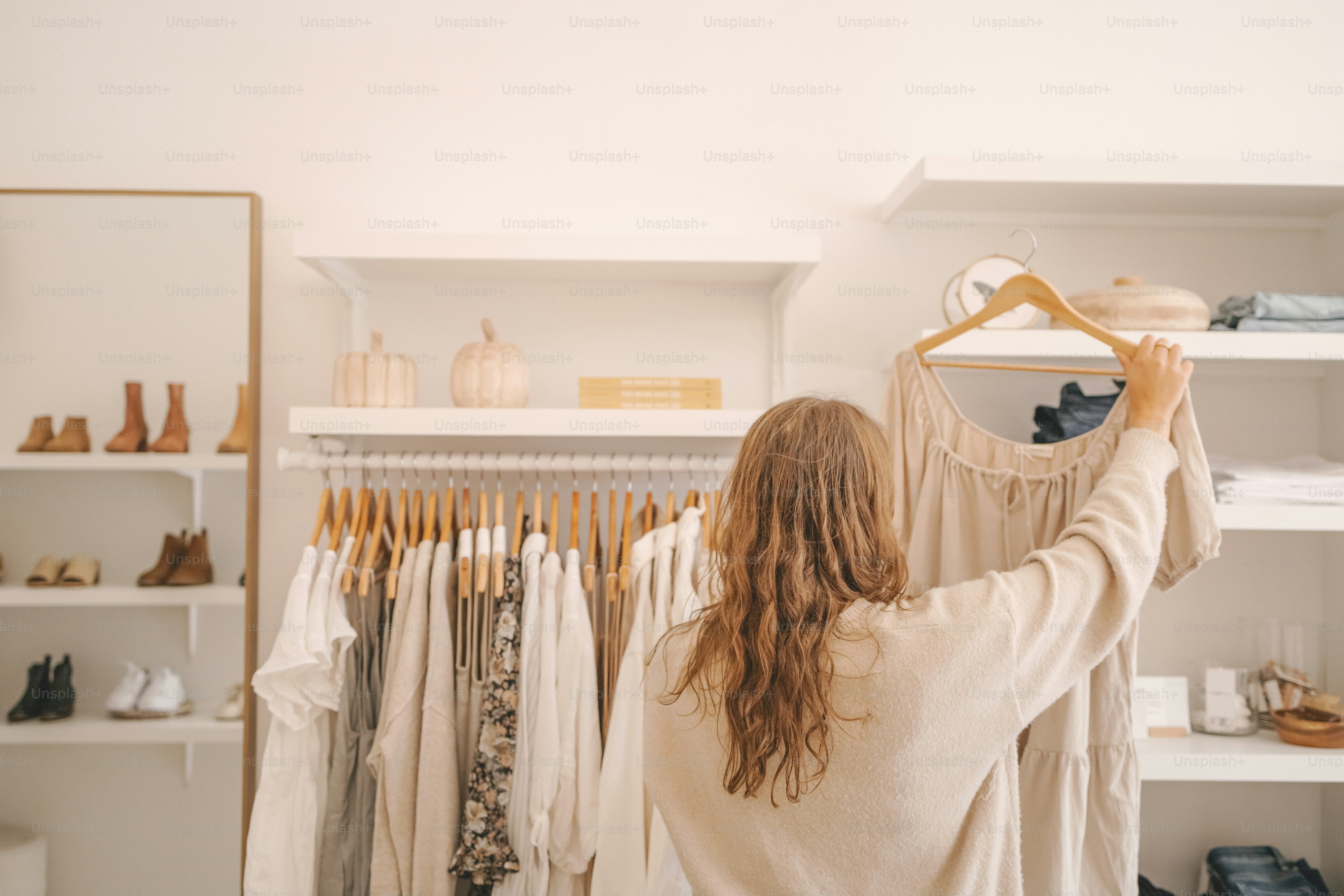 A woman looking at clothes in a clothing store photo – Rack Image on ...