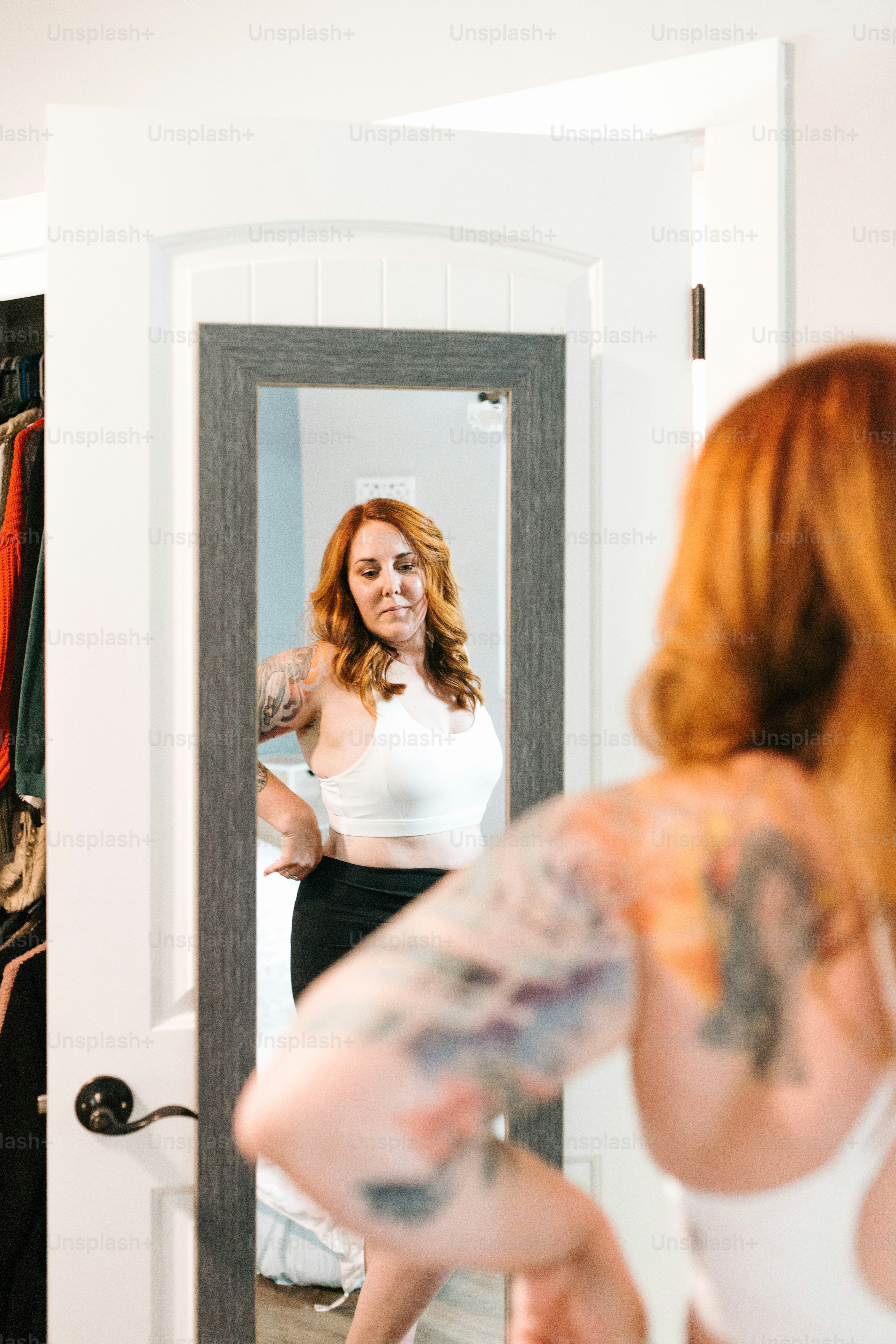 A woman looking at herself in the mirror photo – Food insecurity Image ...