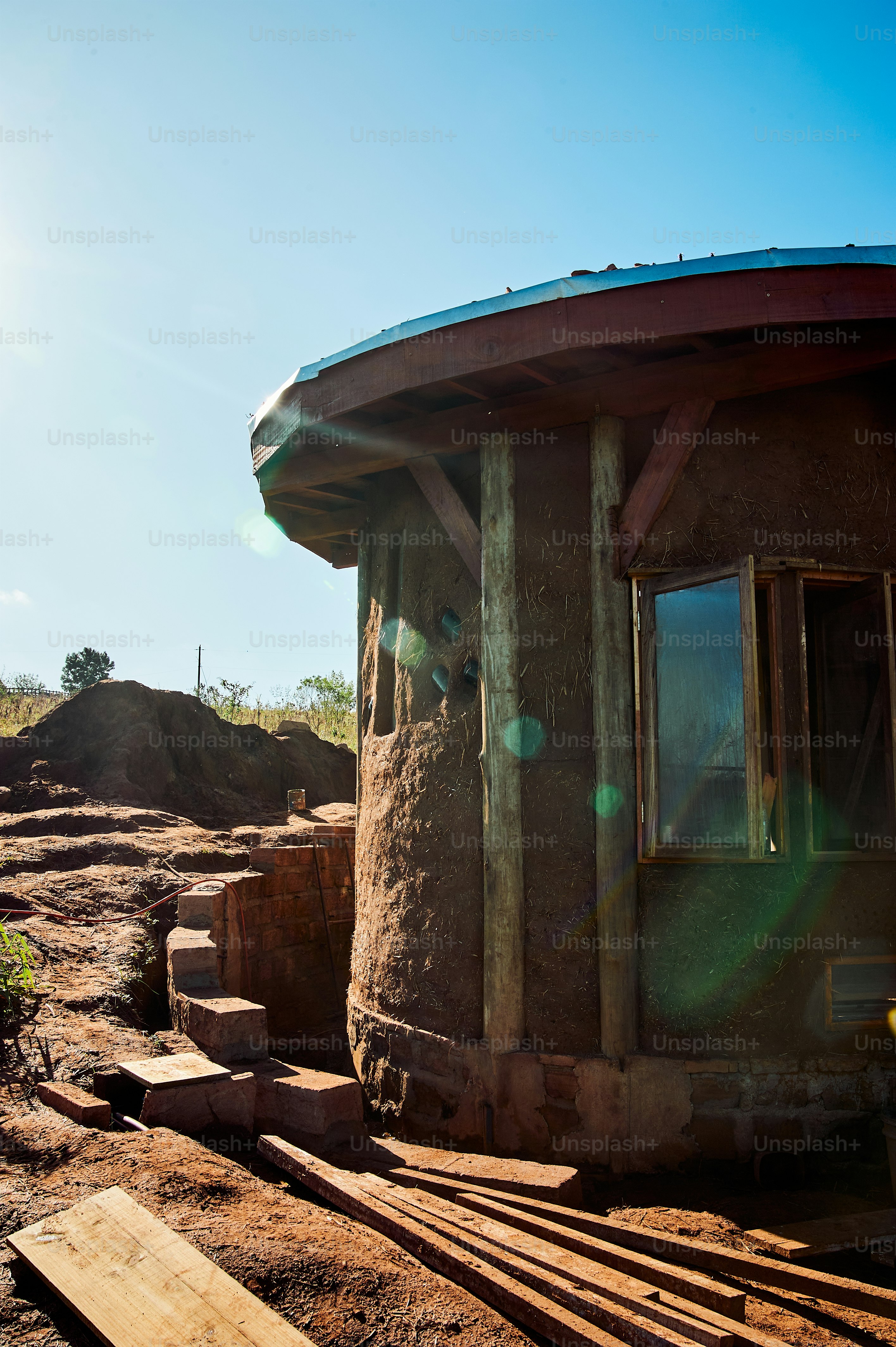 Un bâtiment rond assis au sommet d’un champ de terre photo – Imeuble ...